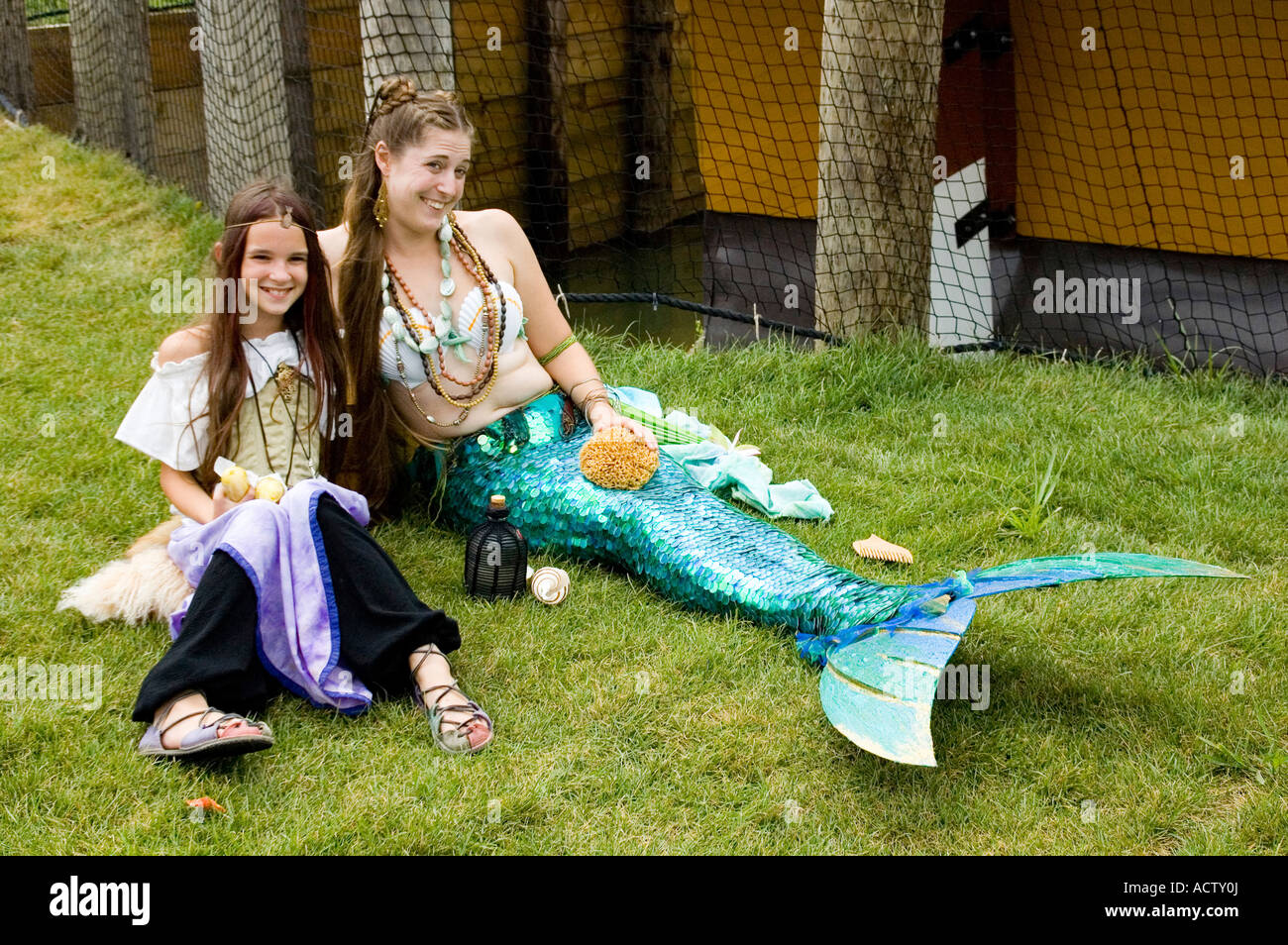 A woman dressed as mermaid and her assistant are taking rest Stock ...
