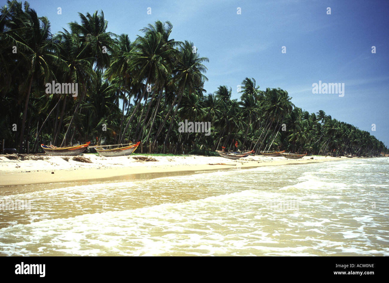 Traditional conical boats rest on the idyllic beach at Mui Nee, Vietnam ...