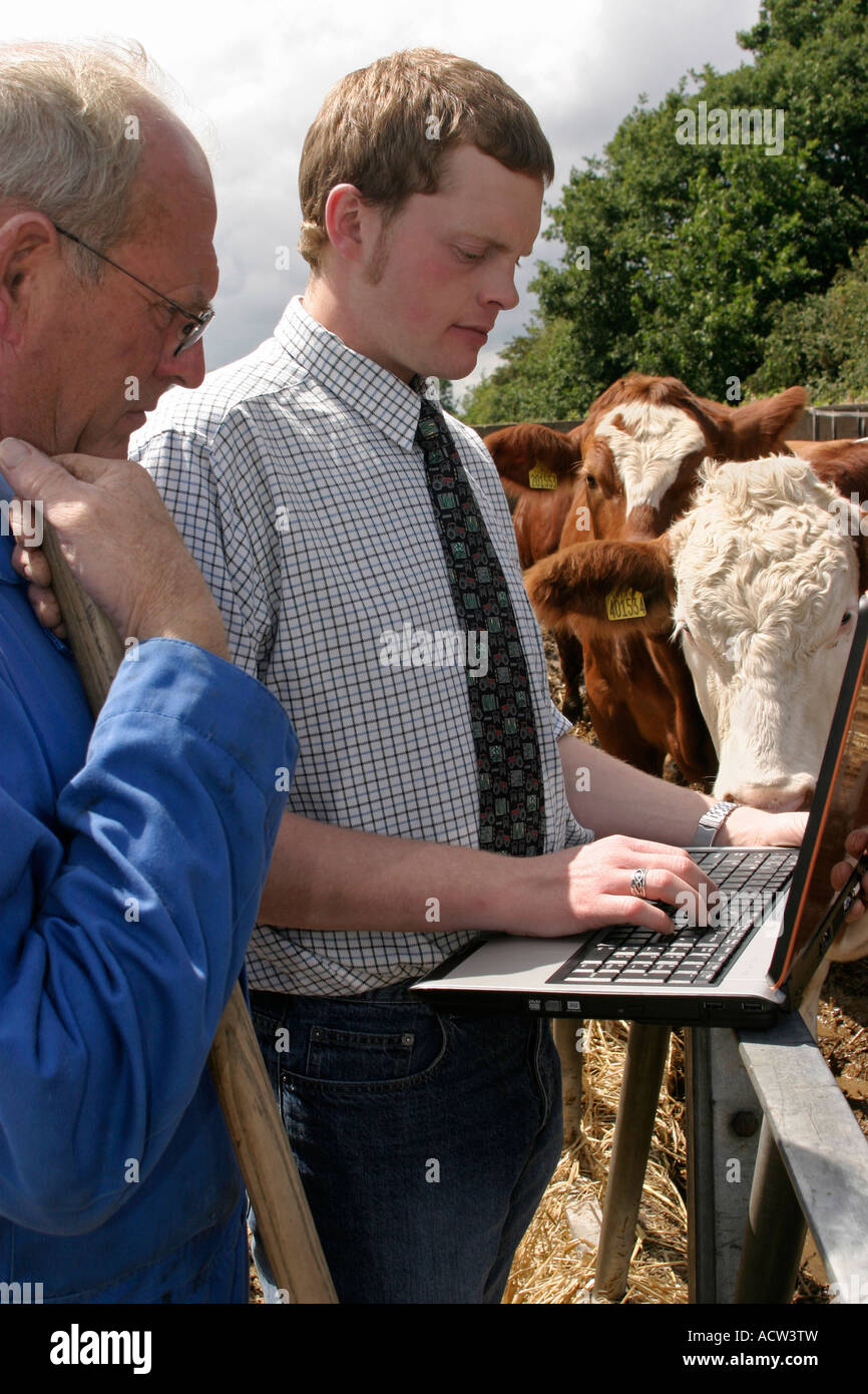Practical use of a laptop computer in farming Two men looking at screen ...