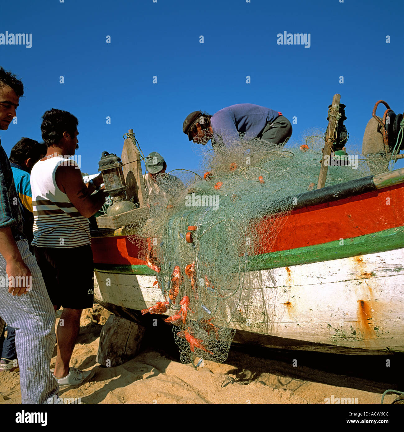 PORTUGAL ALGARVE ARMACO DE PERA FISHERMEN GATHERING FISHES FROM FISHING ...