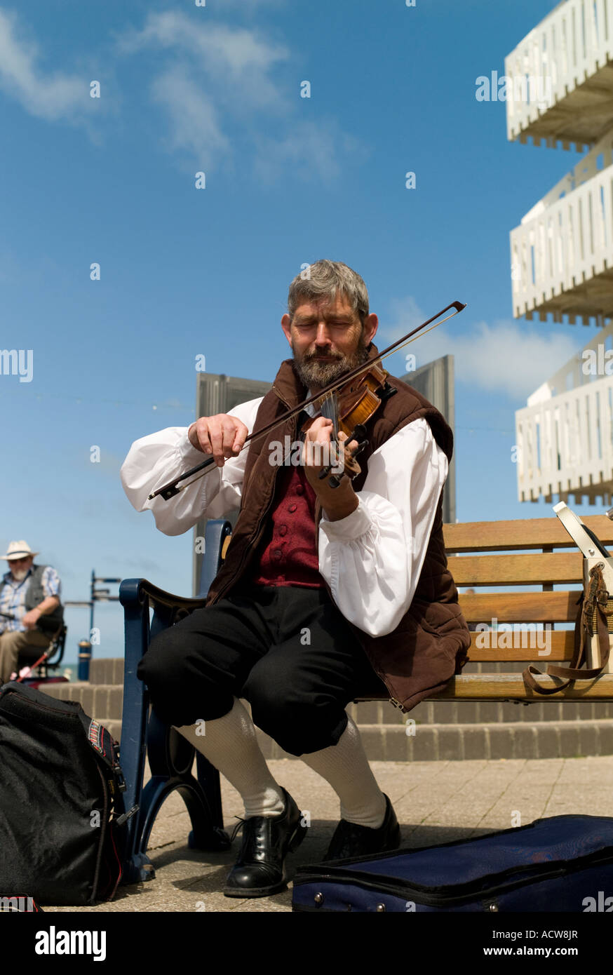 man dressed in traditional welsh folk clothing playing the violin ...
