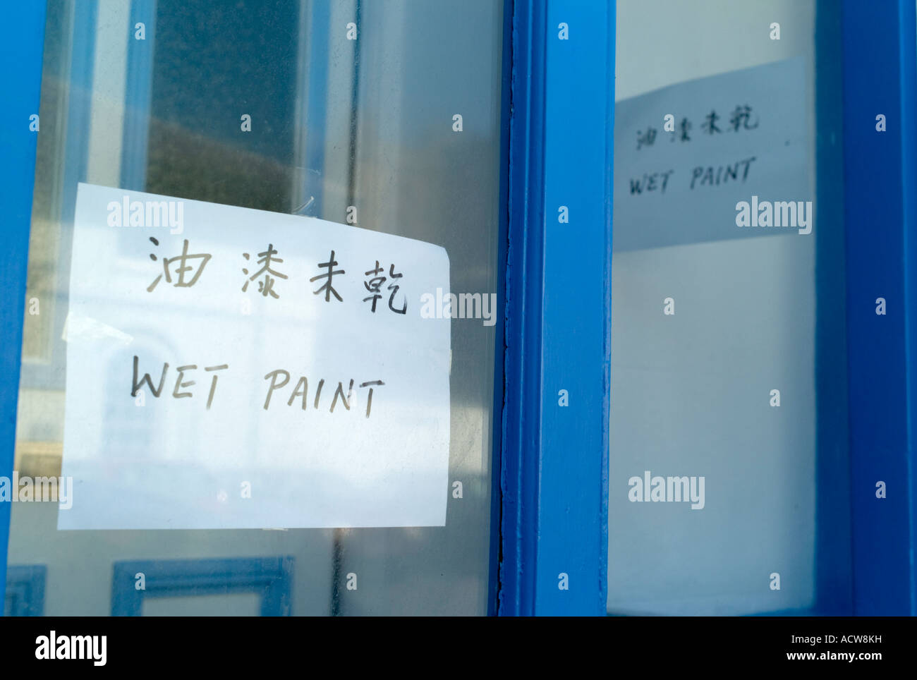 hand written wet paint sign in english and chinese (mandarin) in window ...