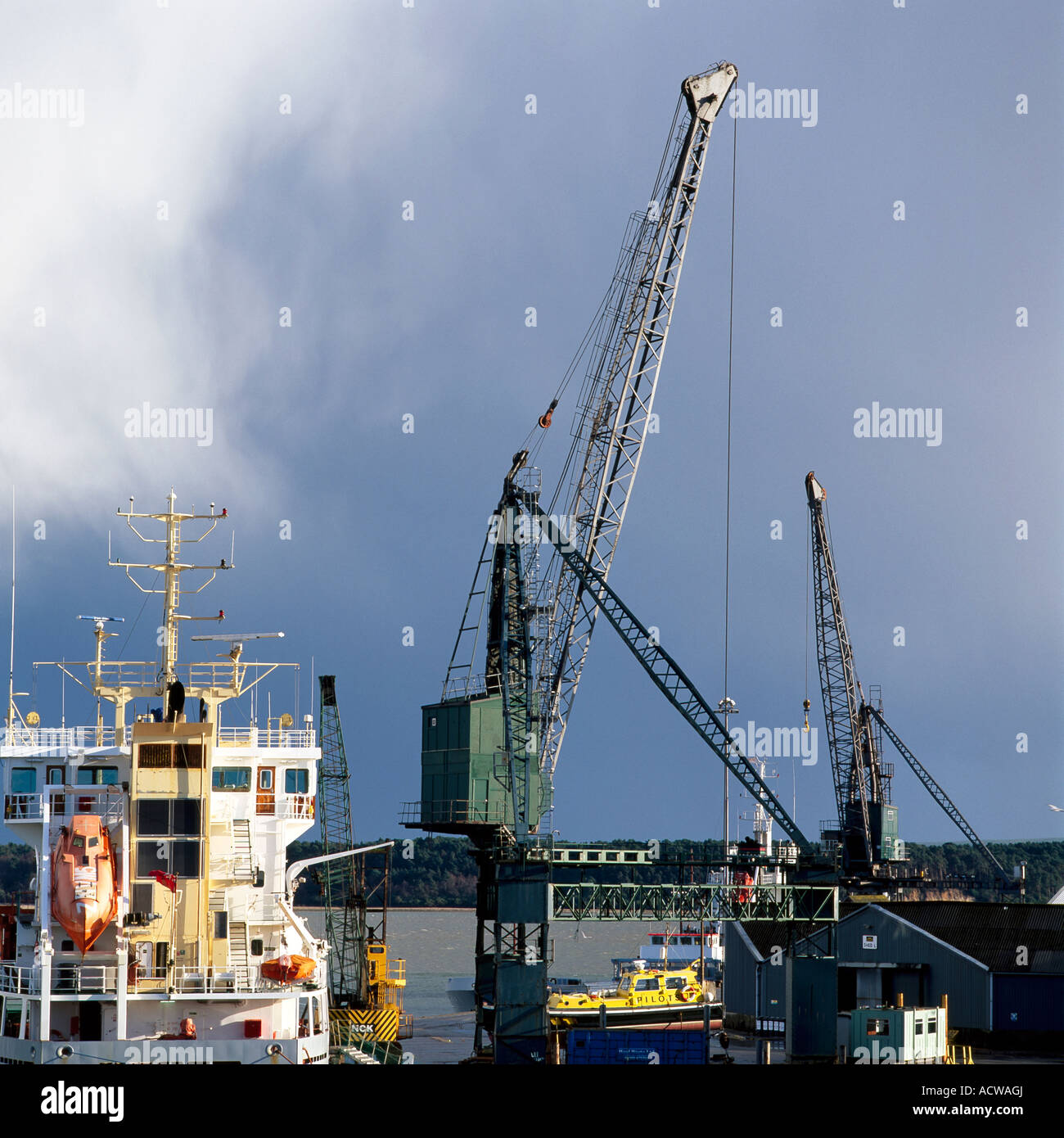 Cargo Ship In Port Under Storm Clouds Alongside A Quay Loading Or ...