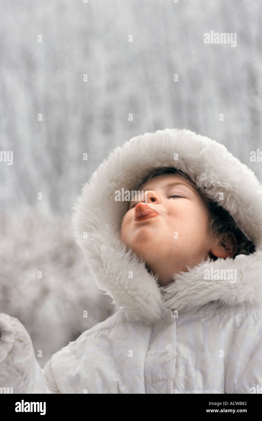 Girl catching snow on tongue Stock Photo - Alamy