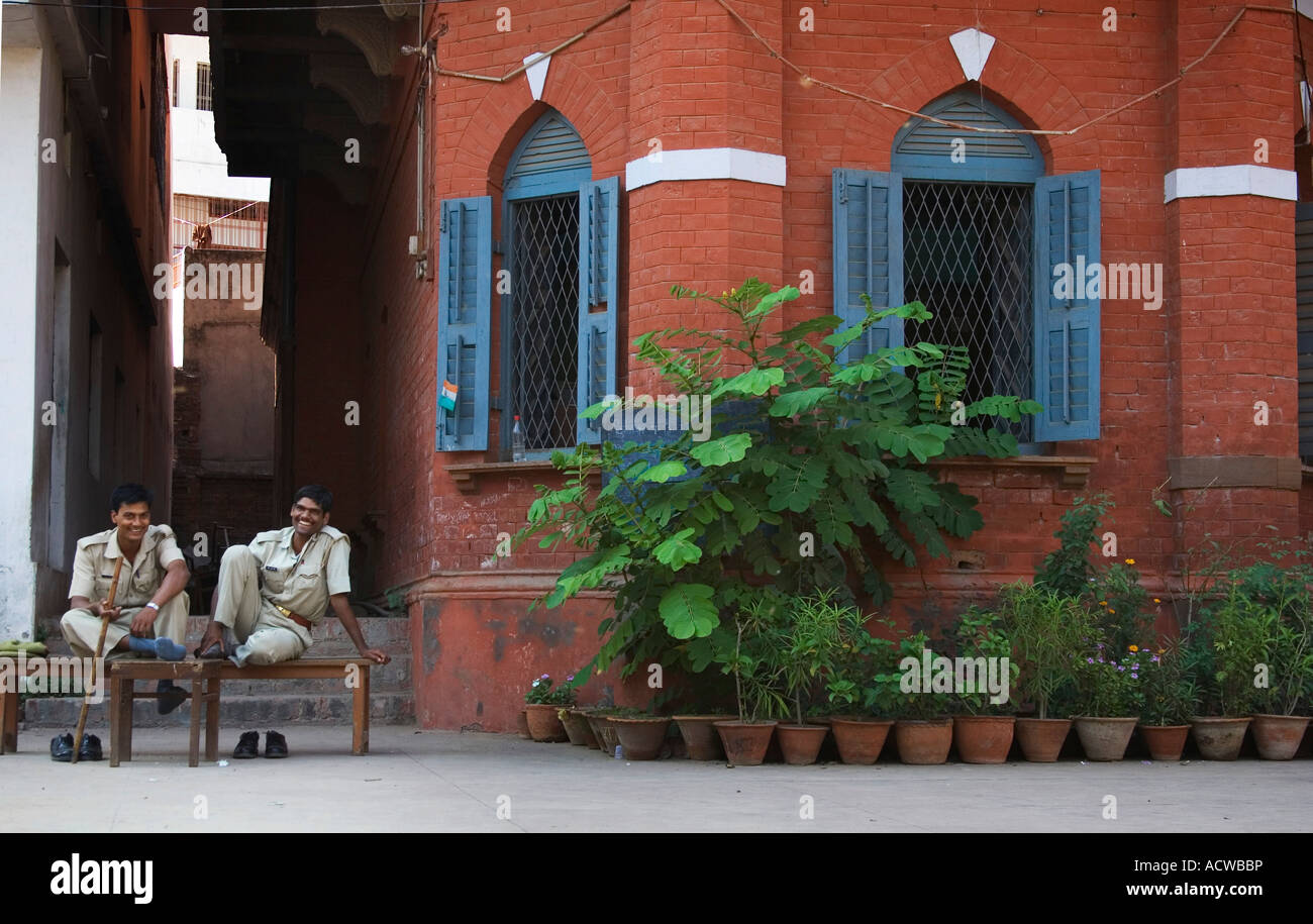 Two policemen relaxing in front of an old house Varanasi Benares India ...