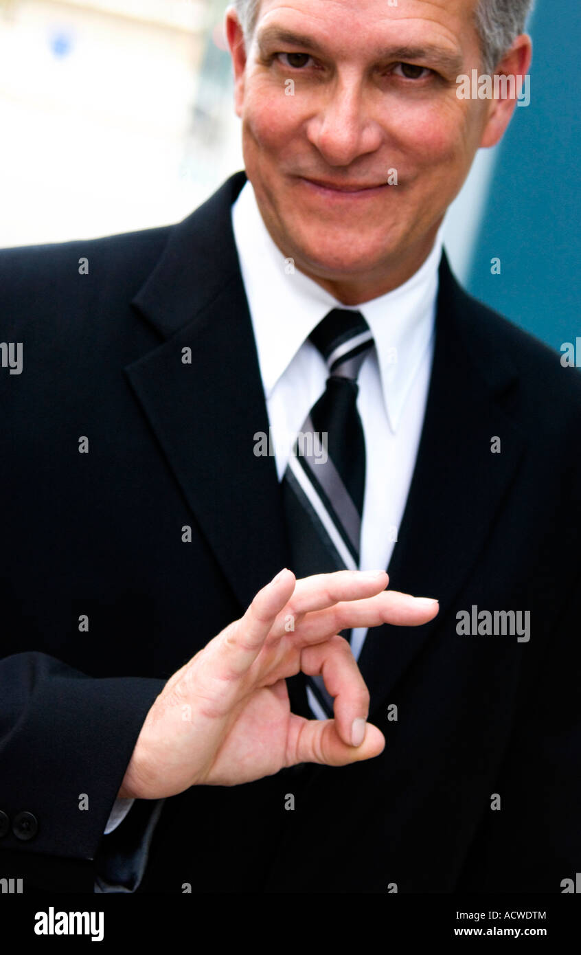 Businessman giving hand signal Stock Photo - Alamy