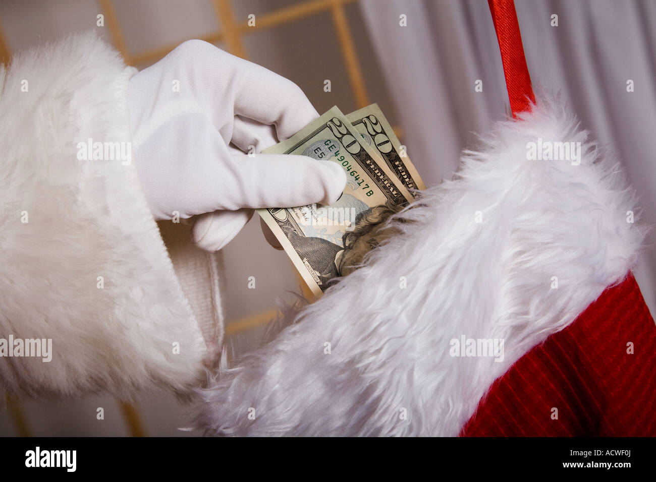 Santa putting money into stocking Stock Photo - Alamy