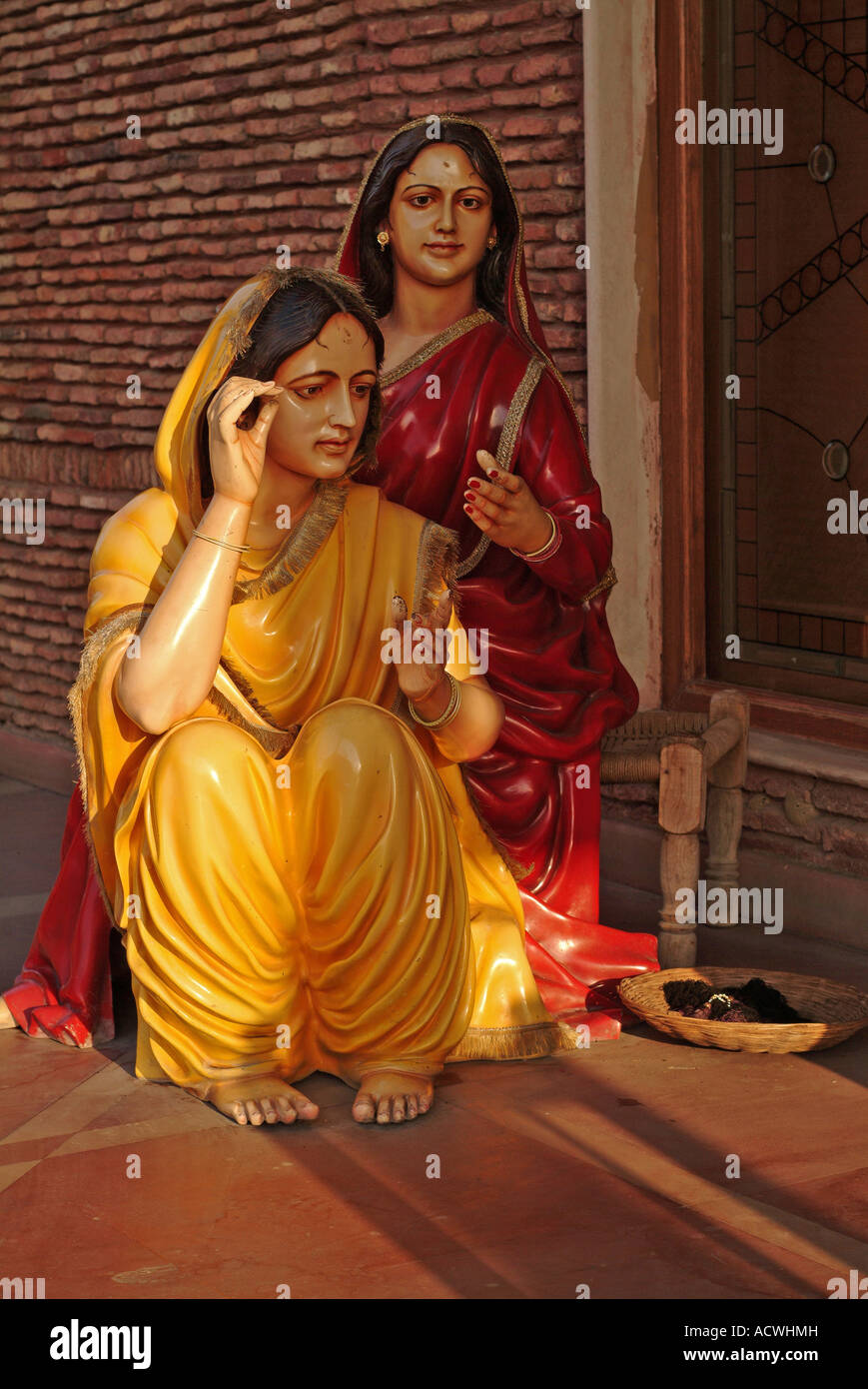 STATUE OF TWO RURAL PUNJABI YOUNG WOMEN FRIENDS SITTING ON STOOLS AND ...