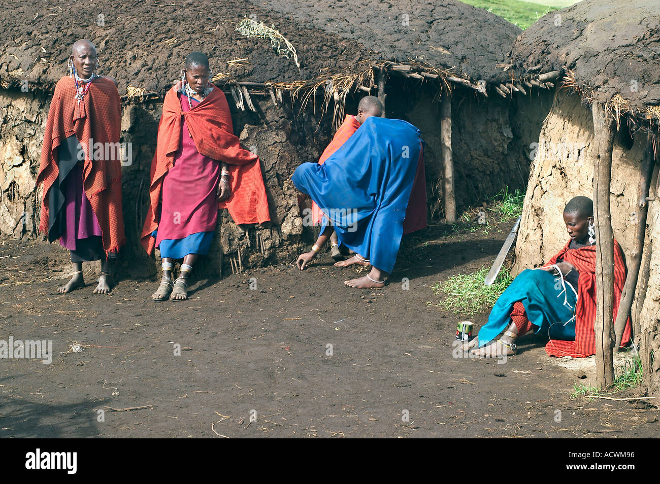 group of maasai in front of their traditional huts Stock Photo - Alamy