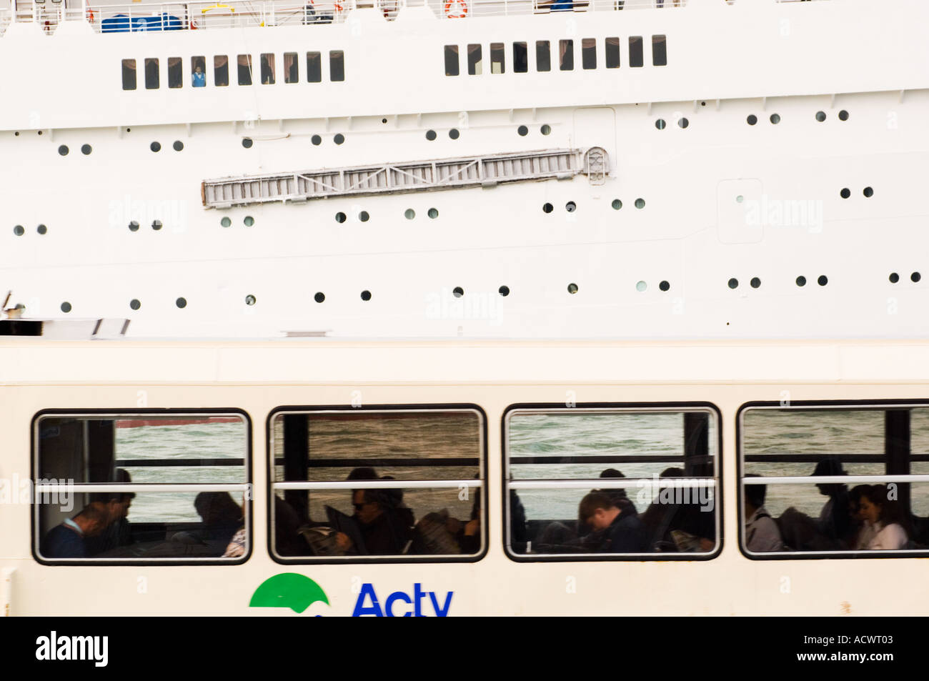 Sides of a small Venice Ferry Bus Boat full of commuters and a large ...