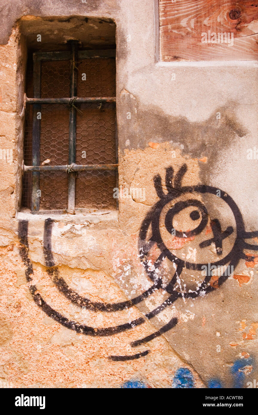brick wall covered with cracked stucco tagged with a graffiti smiling ...