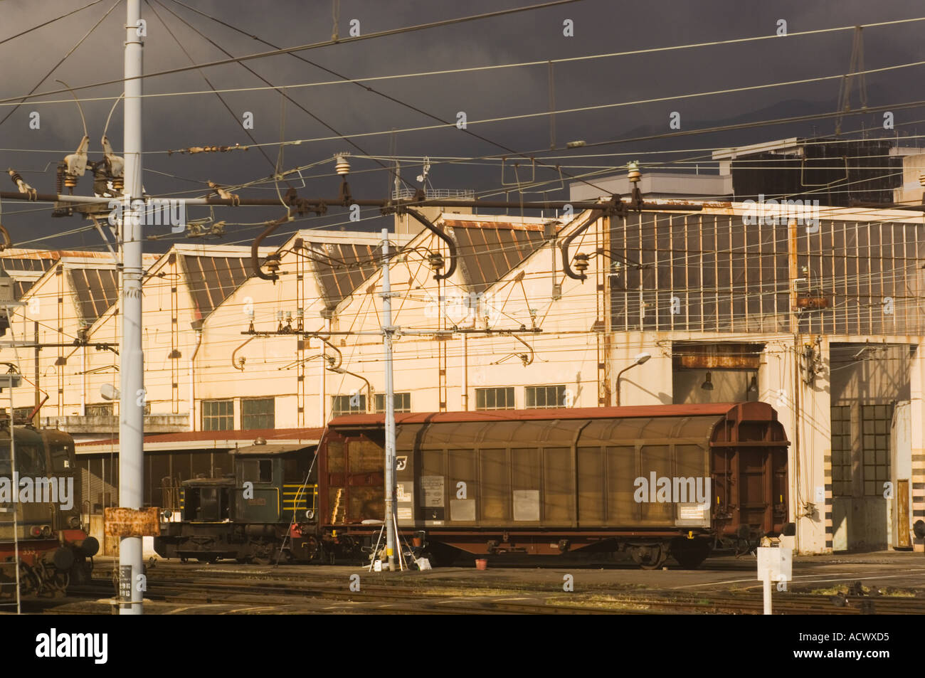 freight trains on a track in Messina Italy in Sicily sunlit with peaked ...