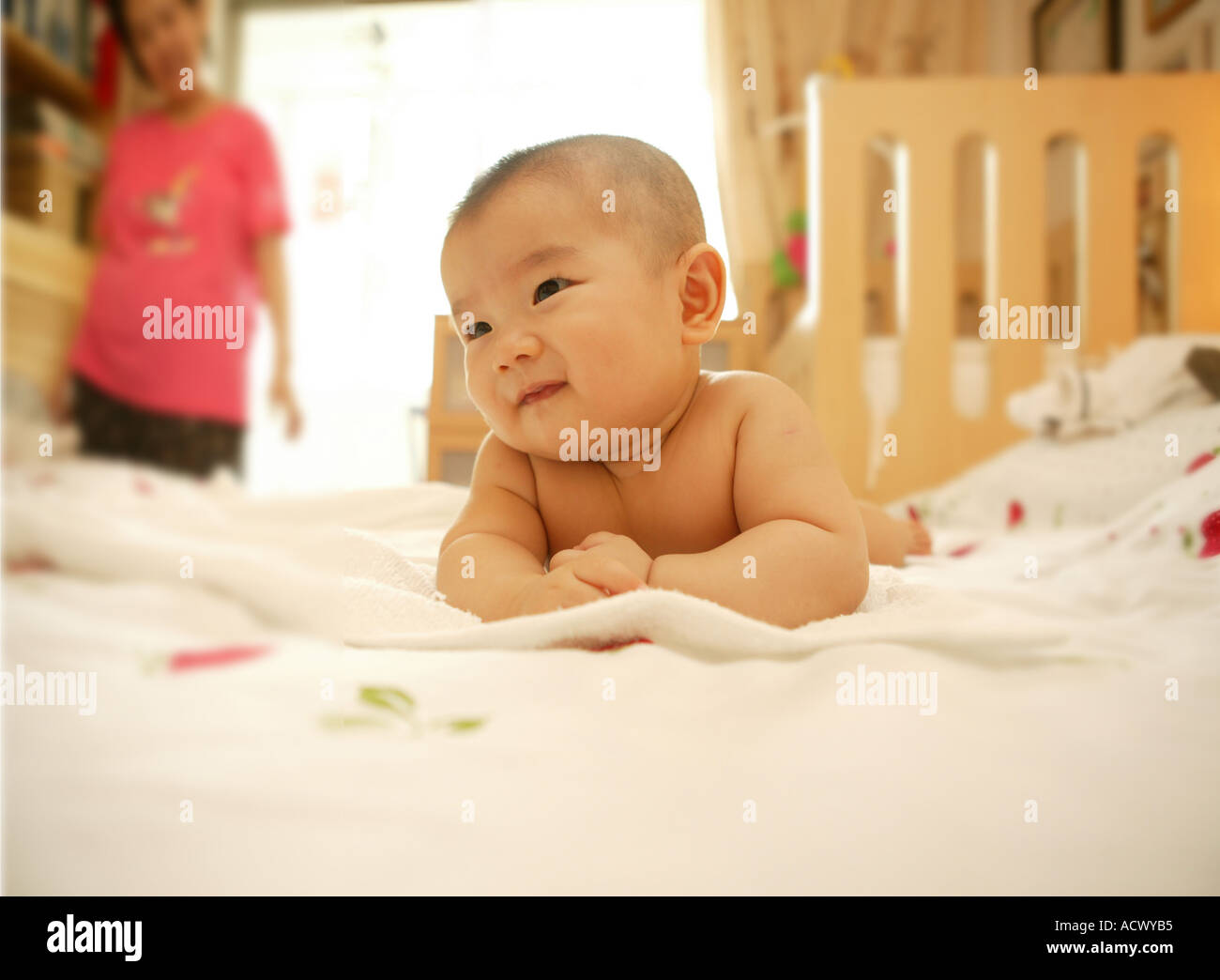 A smiling baby boy lying on bed Stock Photo - Alamy