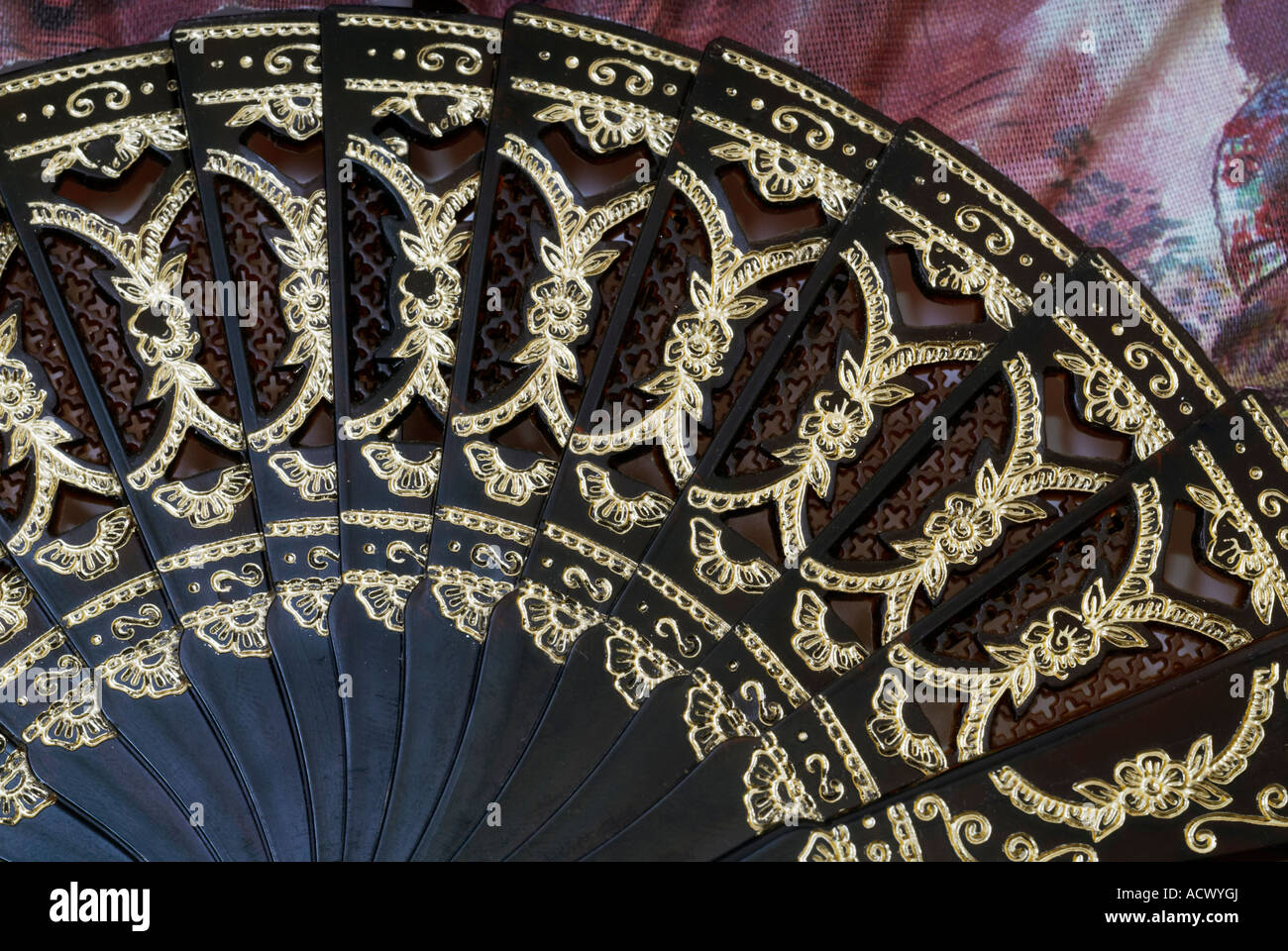 Patterned black and gold fan blades on a ladies fan Stock Photo - Alamy