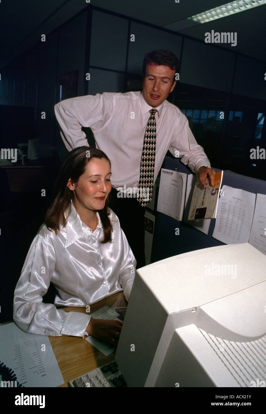 Secretary Using Computer Talking To Man Stock Photo - Alamy