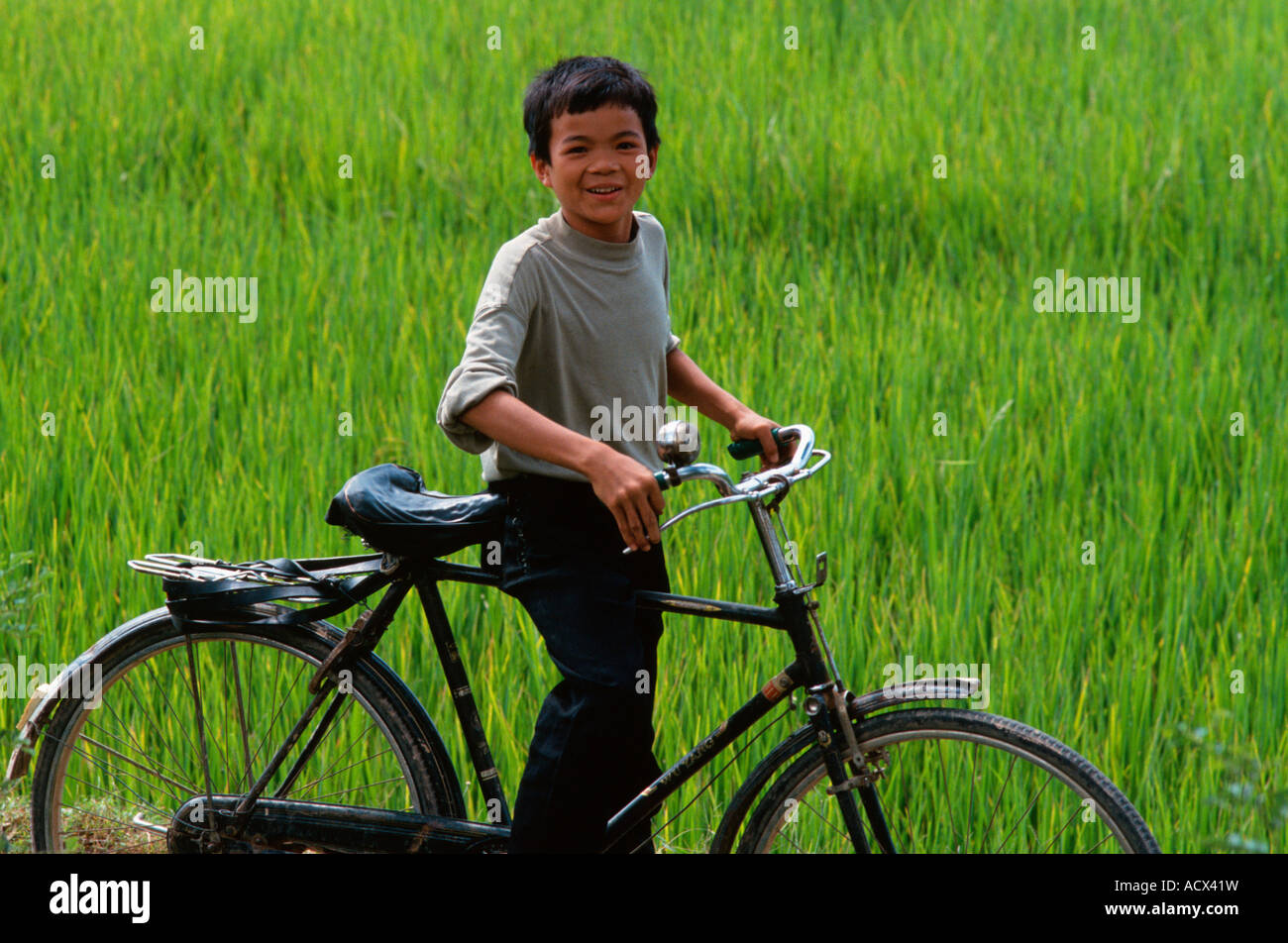 Boy standing astride old bicycle China Stock Photo - Alamy