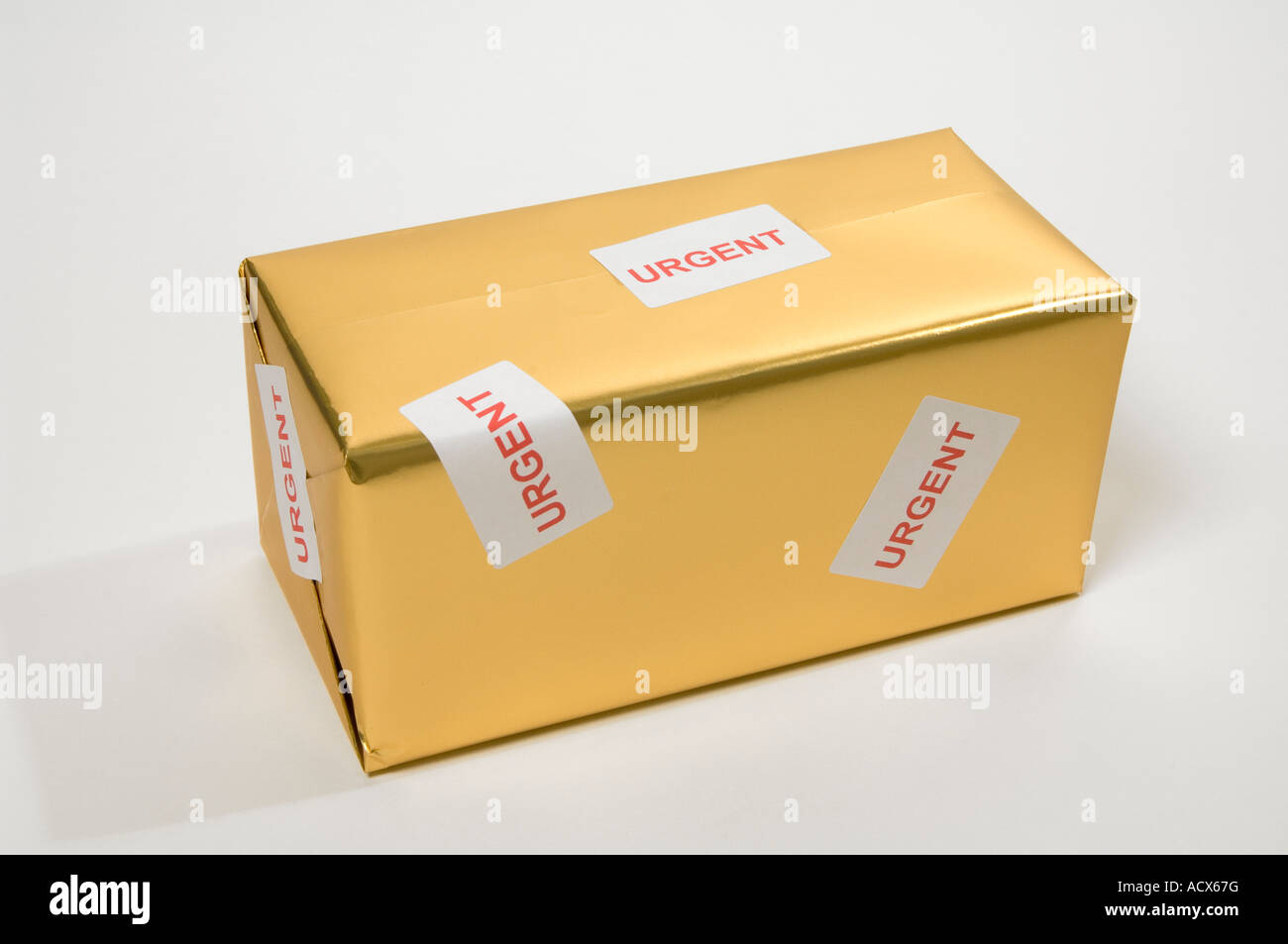 A parcel wrapped in gold paper marked with Urgent stickers Stock Photo ...