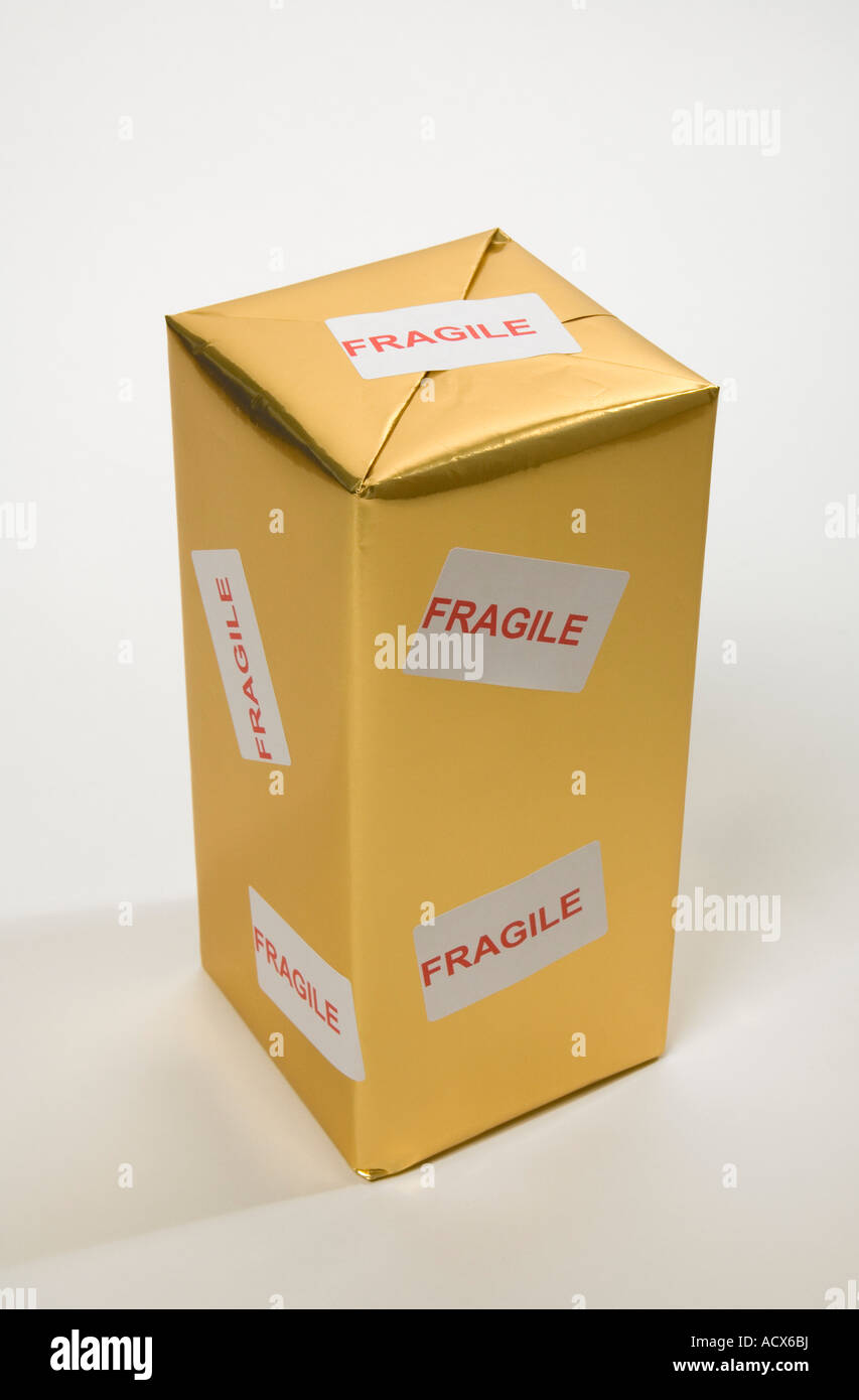 A parcel wrapped in gold paper marked with Fragile stickers Stock Photo ...