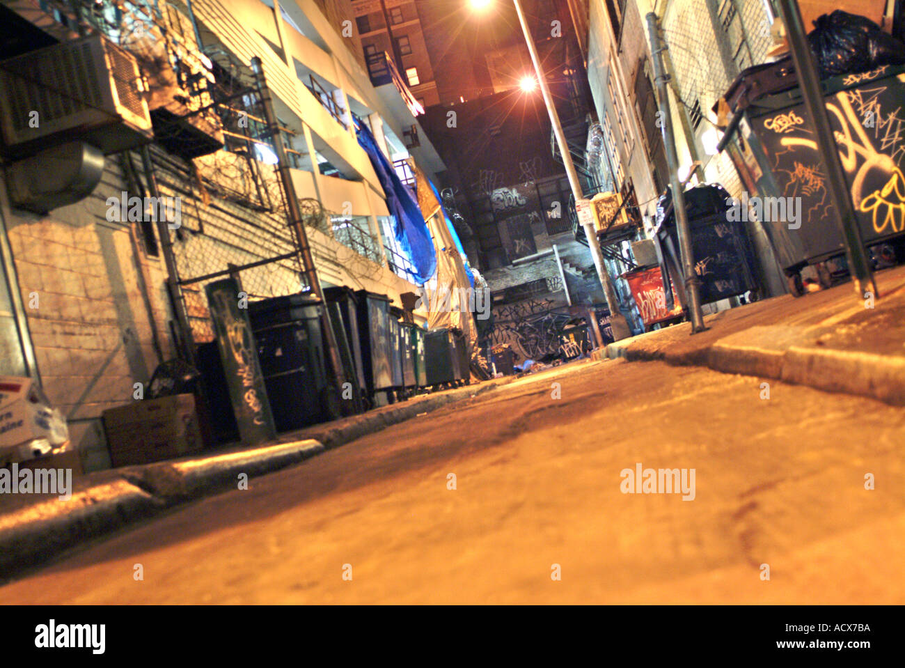 Dark alleyway at night with trash dumpsters and construction debris ...