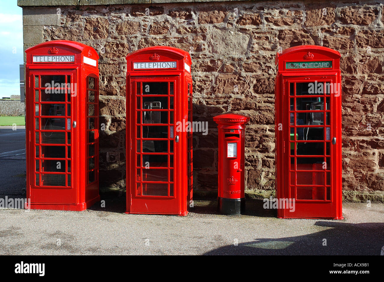 odd one out 3 red telephone boxes and a post box Stock Photo - Alamy
