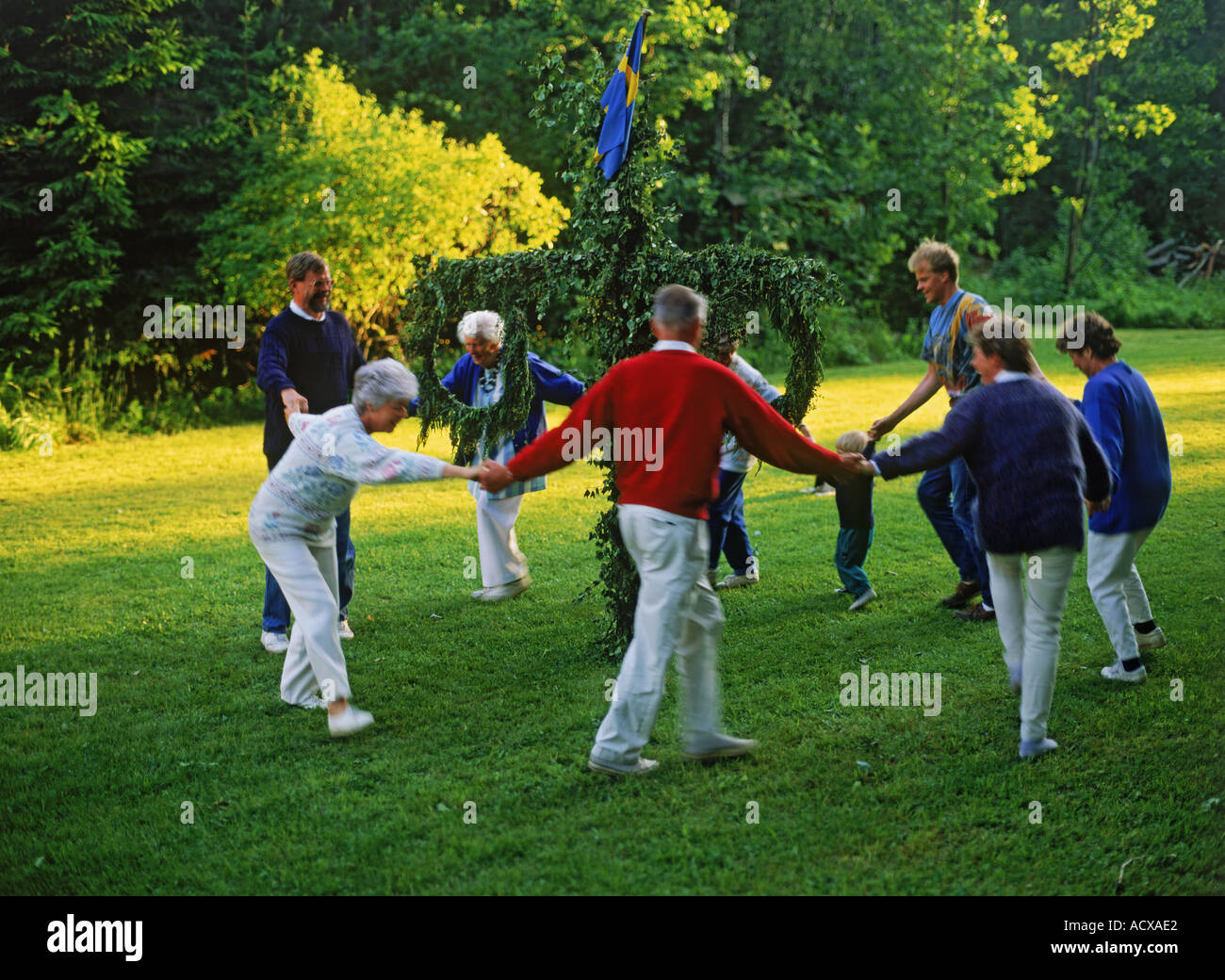 Family dancing around Maypole in Sweden during small traditional ...