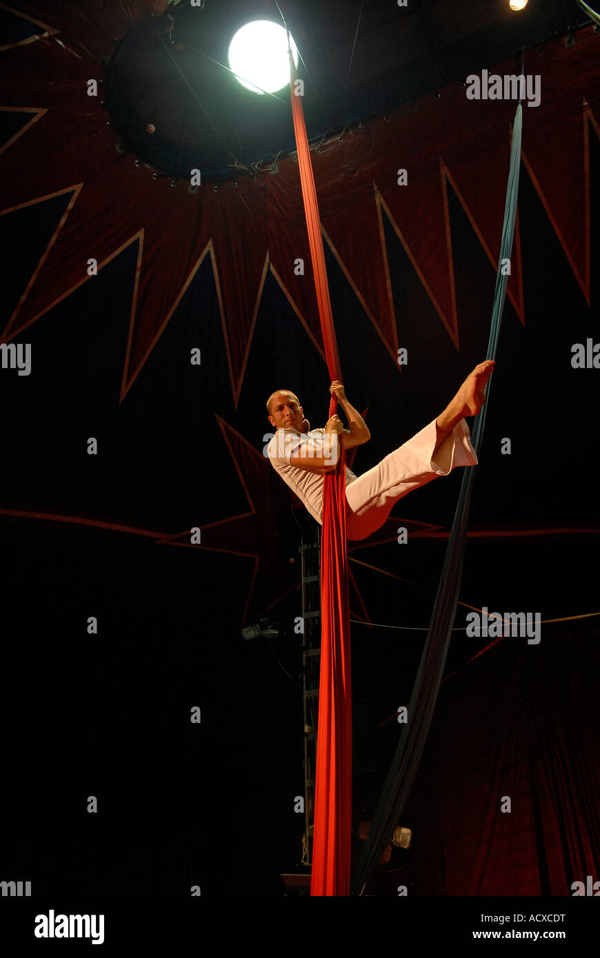 Circus acrobat performer tangled in red drapes Stock Photo - Alamy