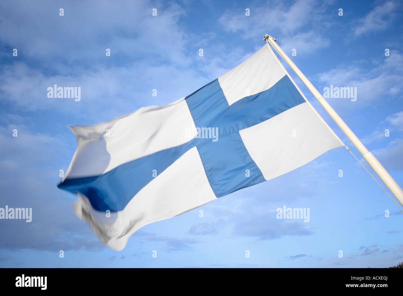 The Blue Cross Flag - Flag of Finland on a background of sky and clouds ...