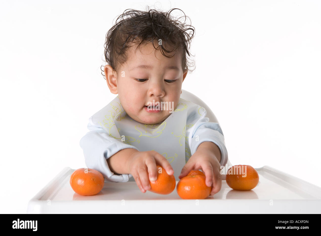 Little toddler boy with mandarin Stock Photo - Alamy