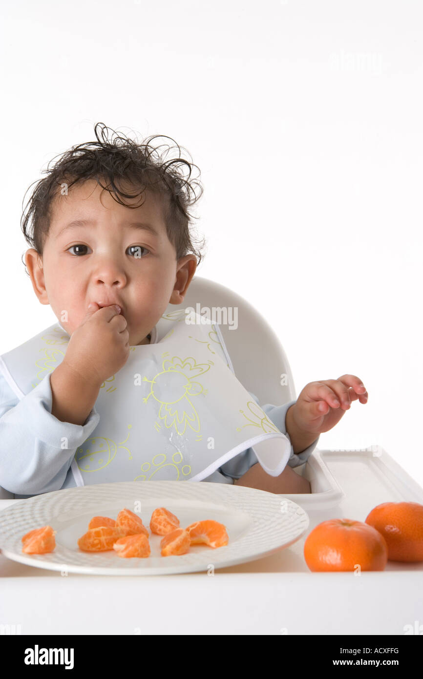 Little boy eating a mandarin Stock Photo - Alamy