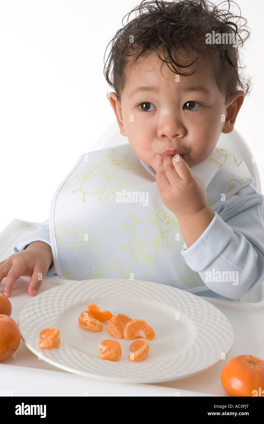Little boy eating a mandarin Stock Photo - Alamy