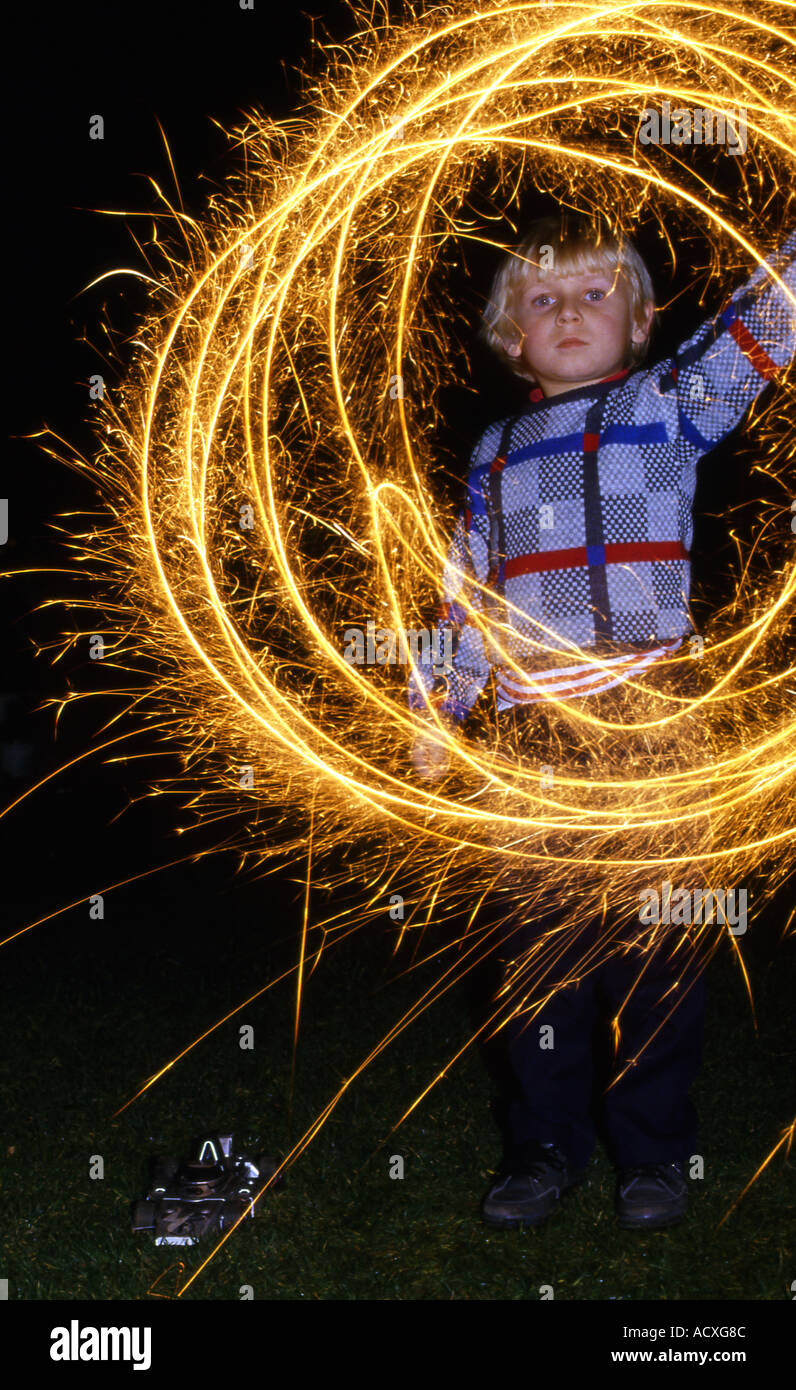 Young boy with sparkler firework shot with flash and a long shutter ...