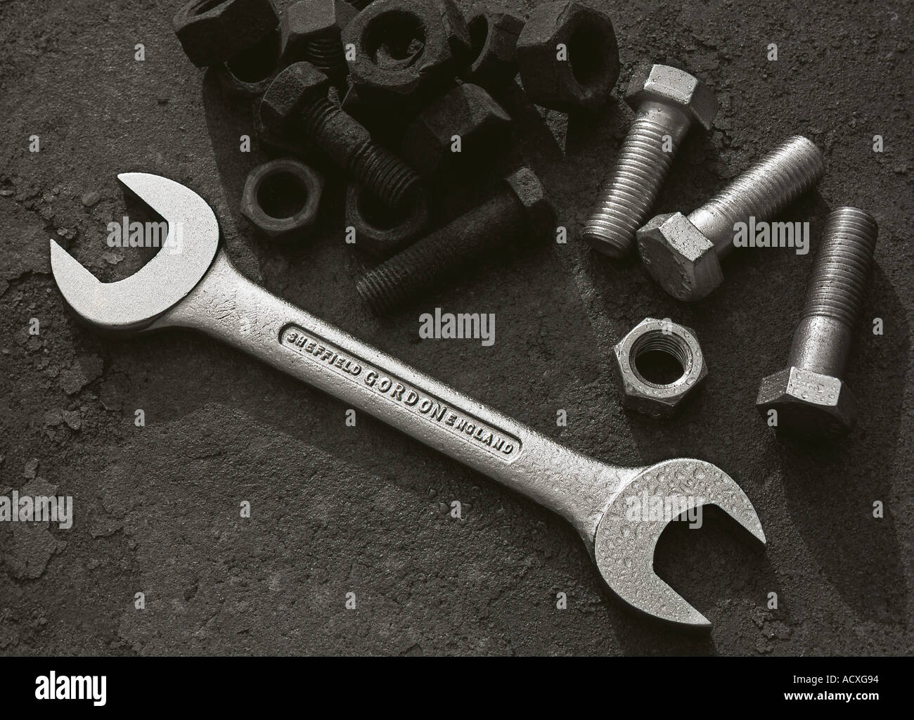 Stainless steel spanner with new nuts and bolts and old rusty bolts in ...