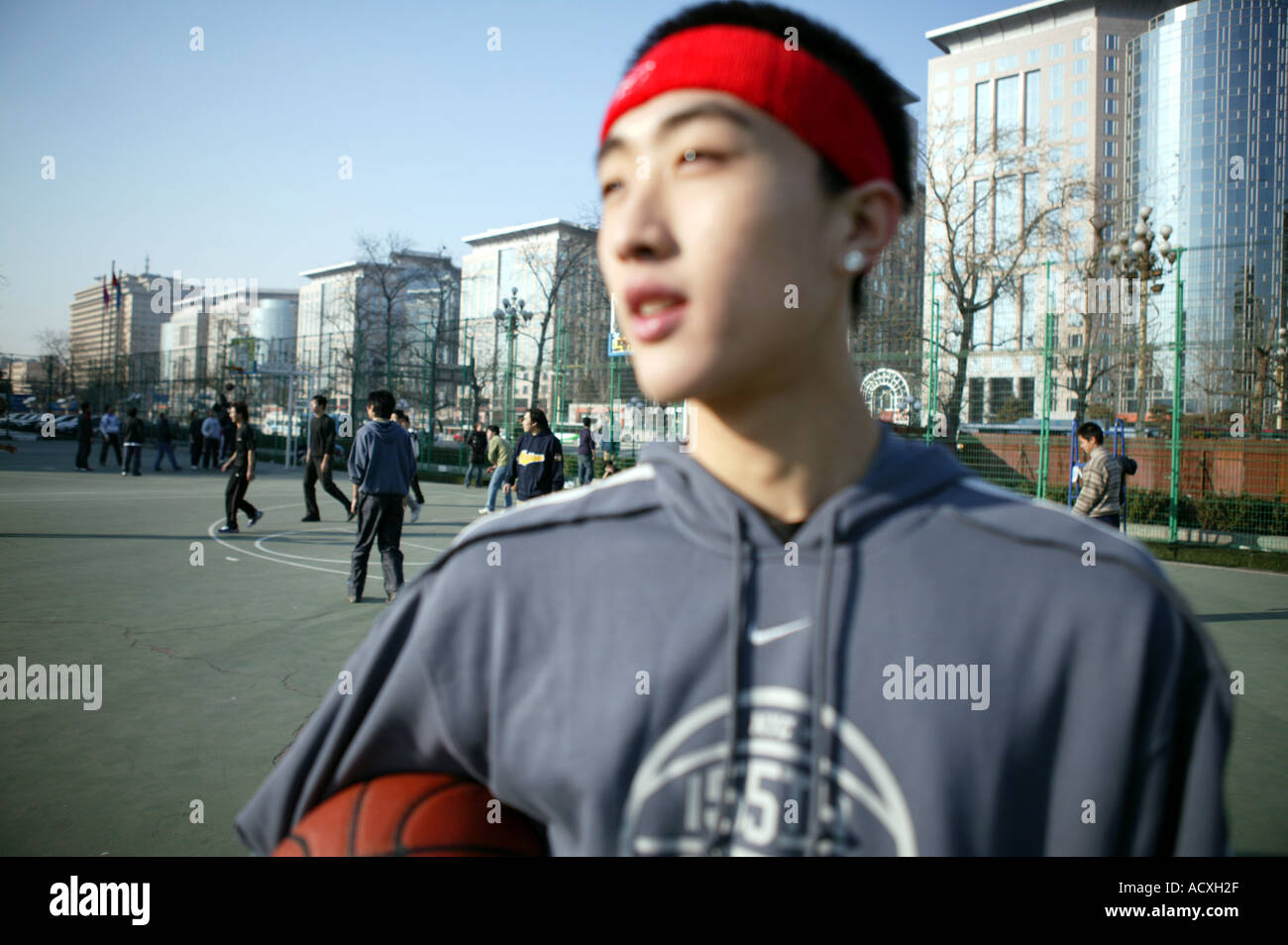 a Chinese student holding a basketball in a playground Stock Photo - Alamy