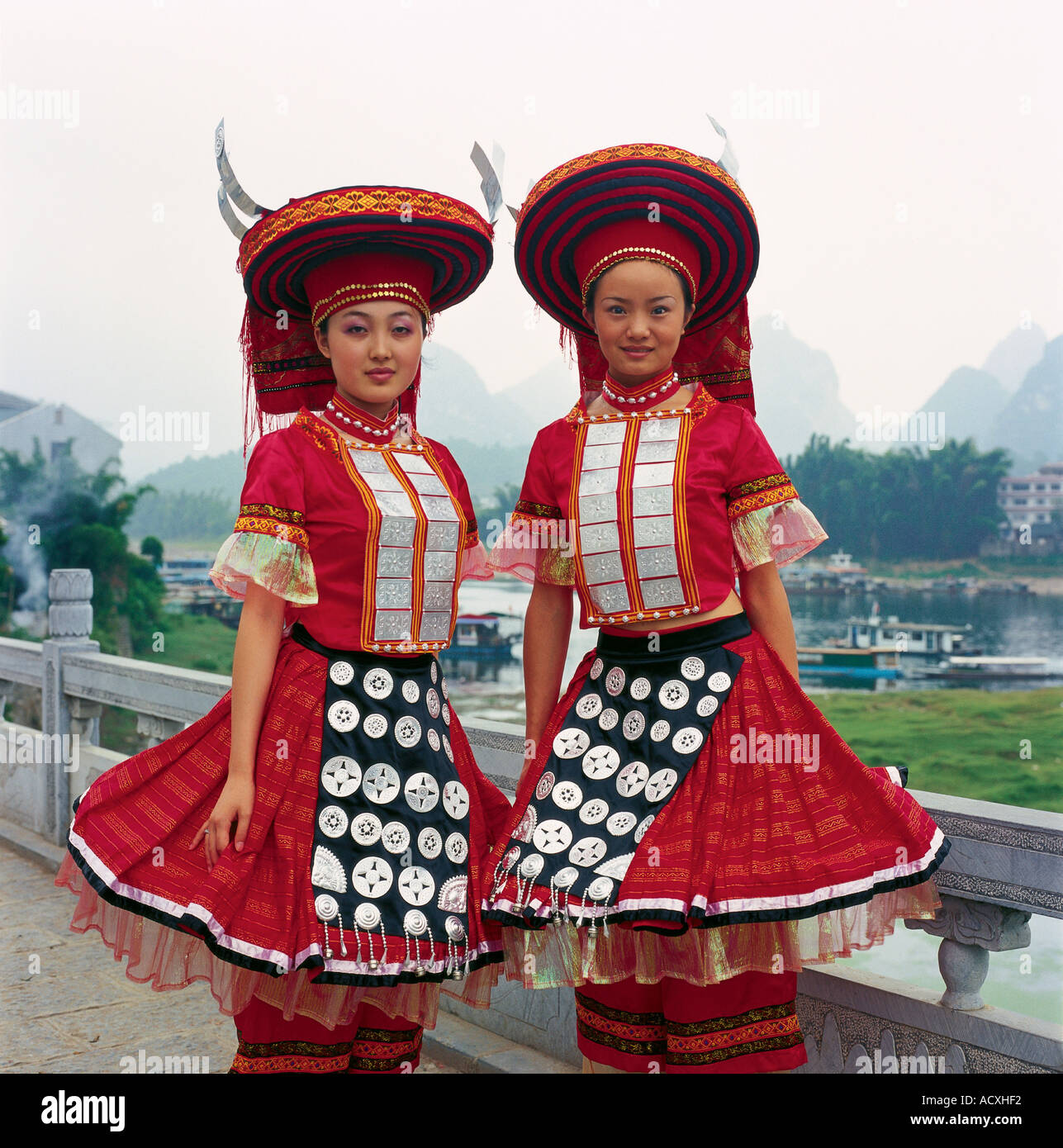 portrait of two young women with traditional clothing smiling at camera ...