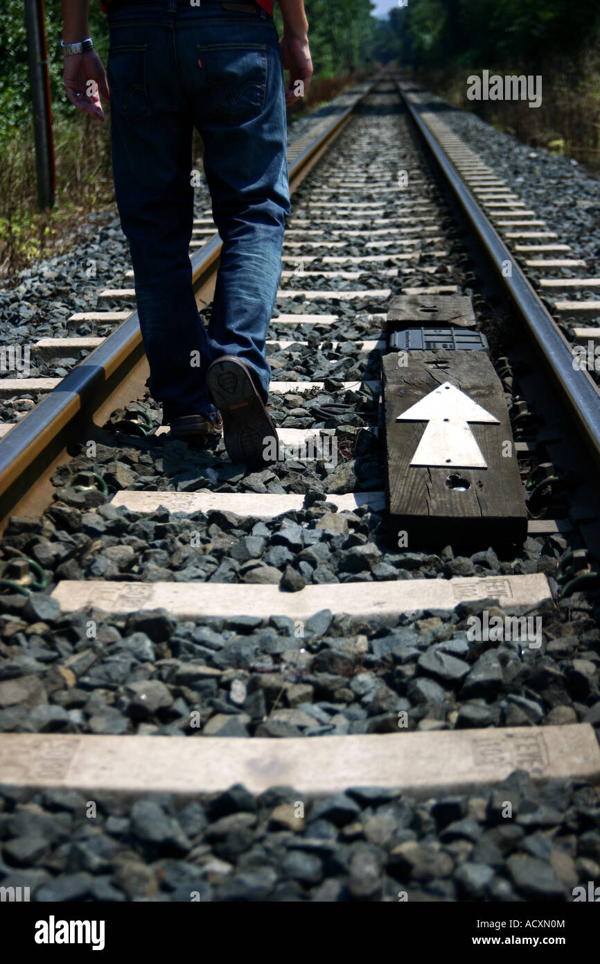 Man walking between two rails Stock Photo - Alamy