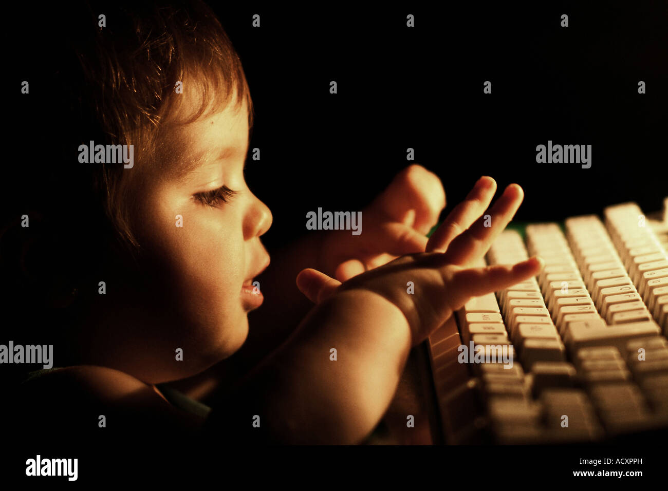 Baby girl typing on a PC keyboard Stock Photo - Alamy
