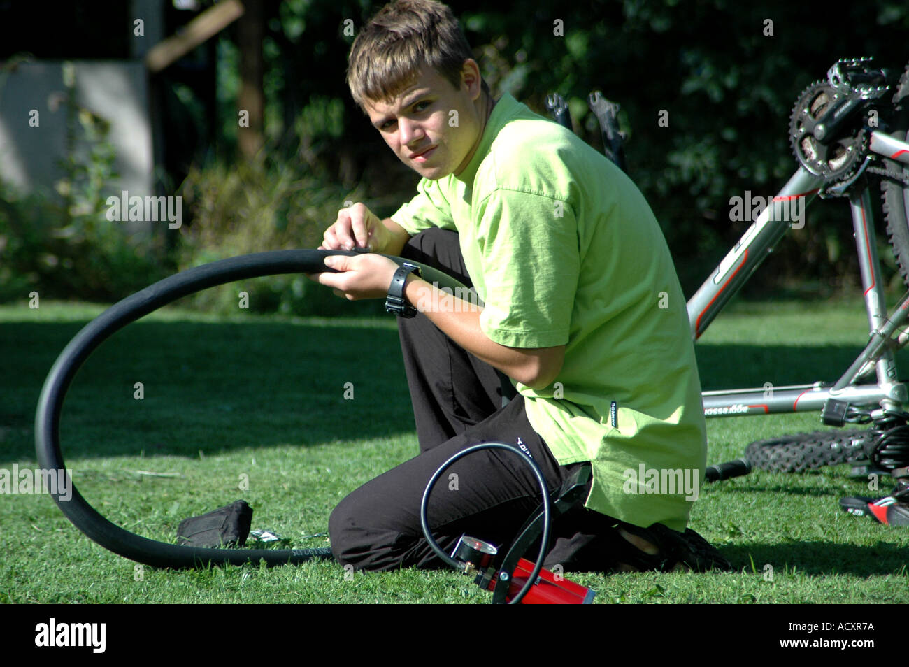 Teenage boy mending a bicycle puncture in the garden Stock Photo - Alamy