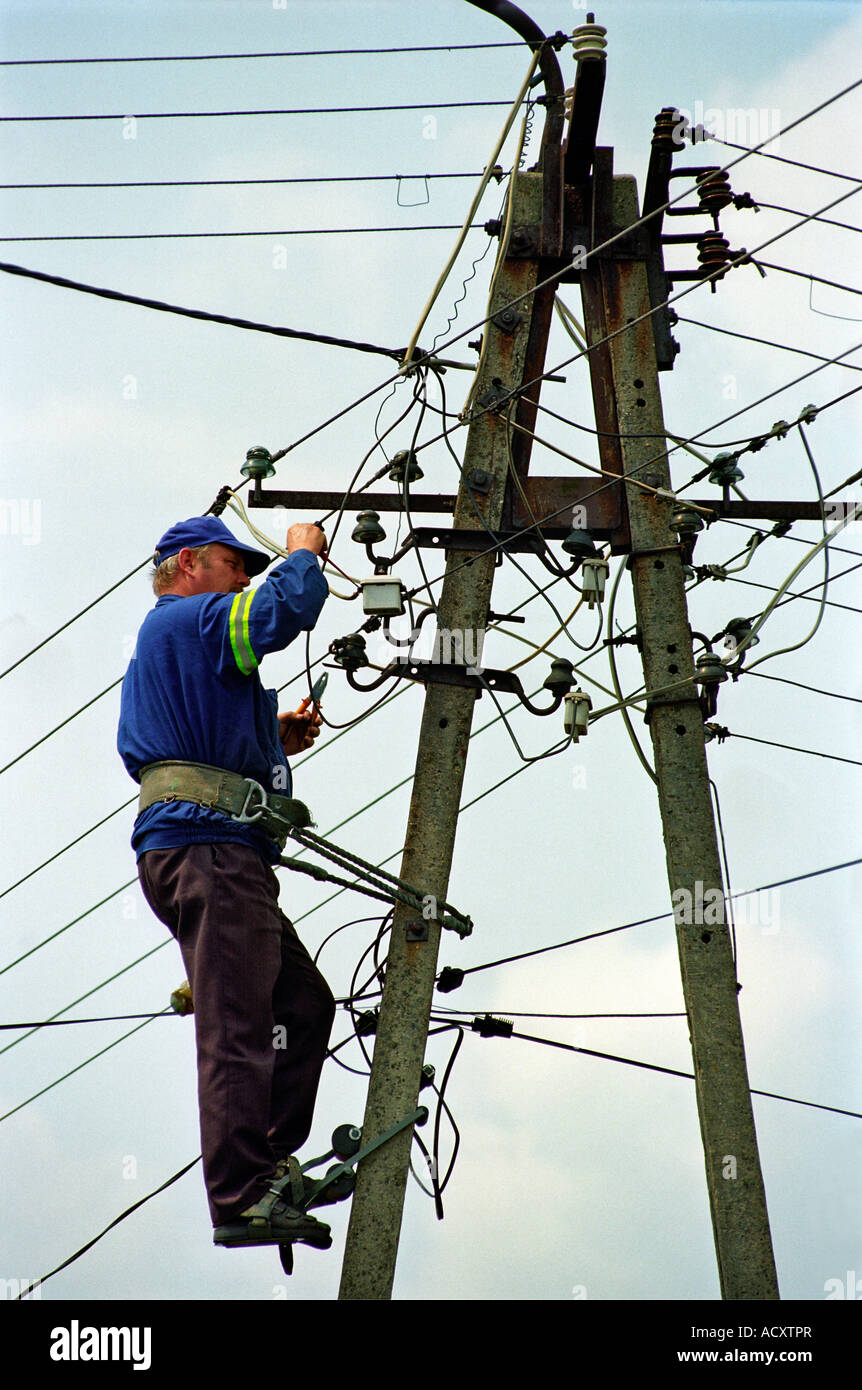Worker repairing a power pylon, Poland Stock Photo - Alamy