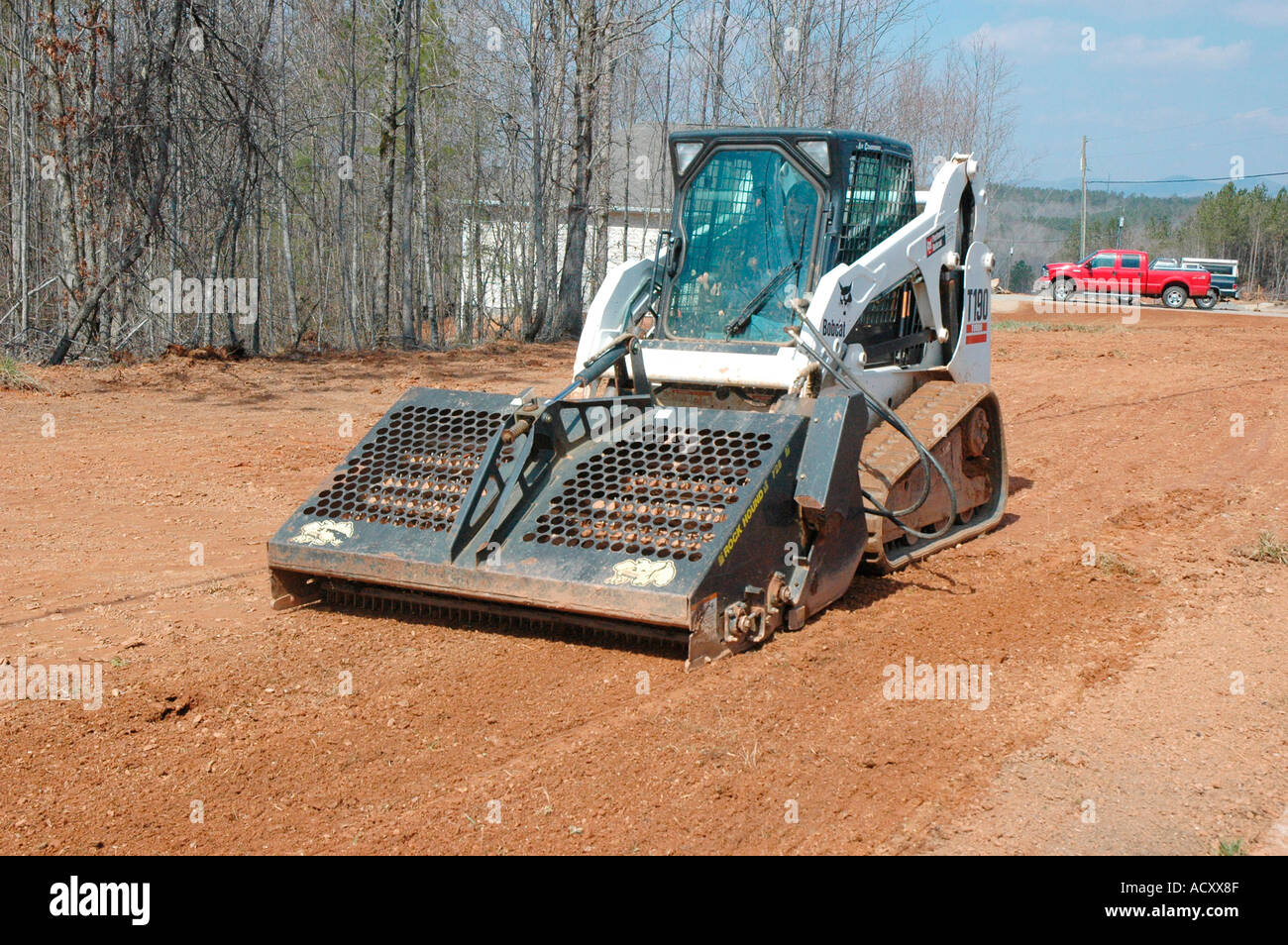 Getting yard ready for grass sod with rakes and rock hound on tractor ...