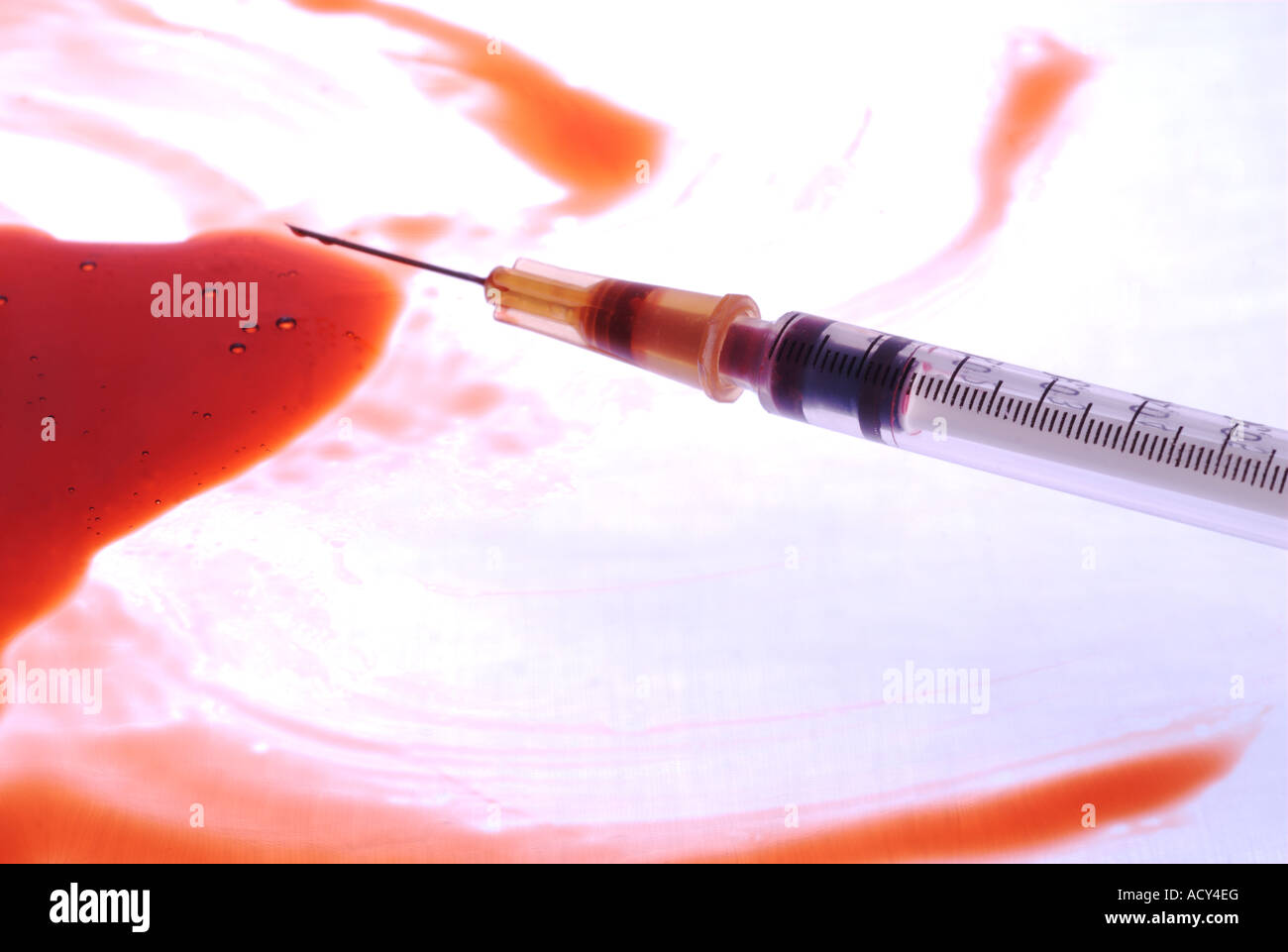 hypodermic needle and smeared blood on a white background with space ...