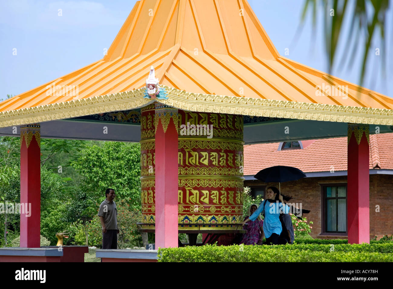 Women spinning a big prayer wheel. German Buddhist monastery. Lumbini ...