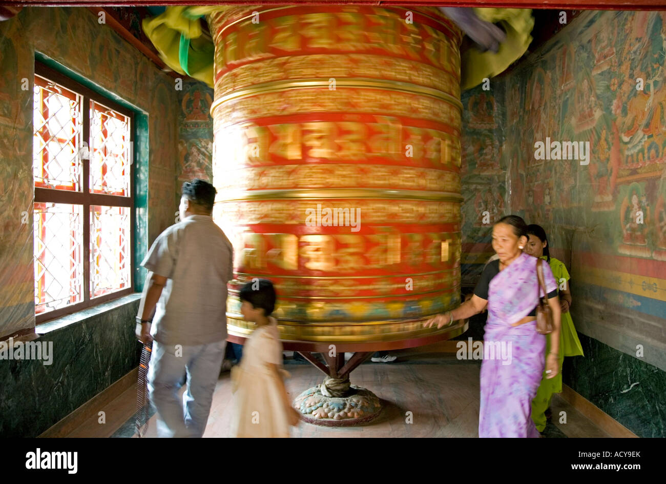 Pilgrims spinning a big prayer wheel.Tsamchen Gompa.Bodhnath Stupa ...