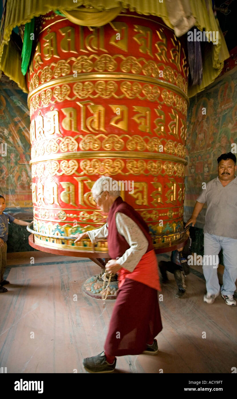 Tibetan nun spinning a big prayer wheel.Tsamchen Gompa.Bodhnath Stupa ...