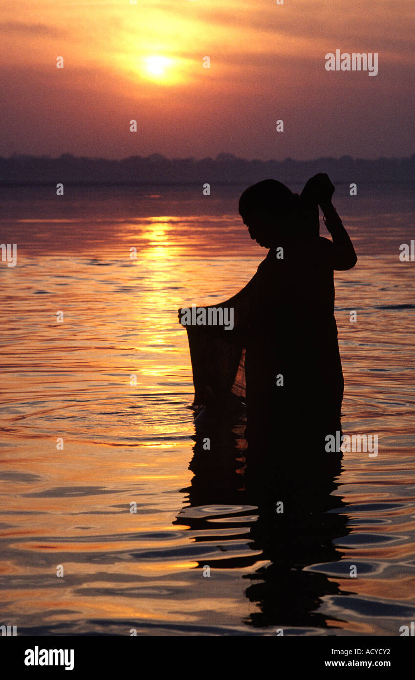 A faithful HINDU WOMAN bathes and performs ablutions in the GANGES ...