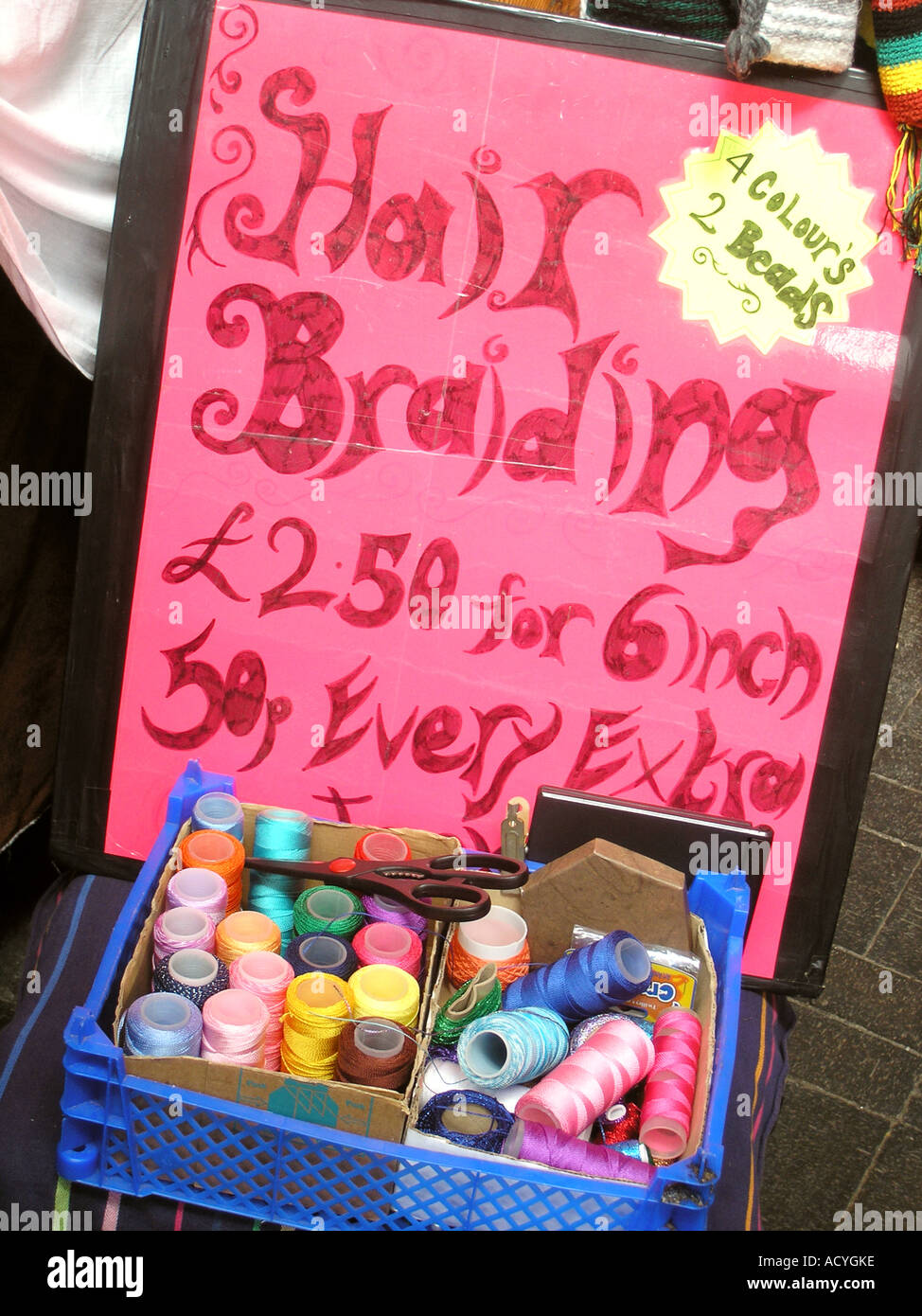 pink advertisement sign for hair braiding at indoor market Barncastle ...