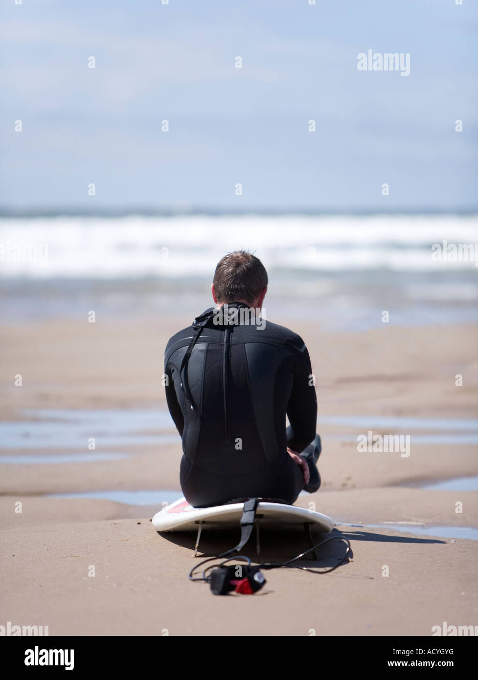 Surfer resting on beach Stock Photo - Alamy