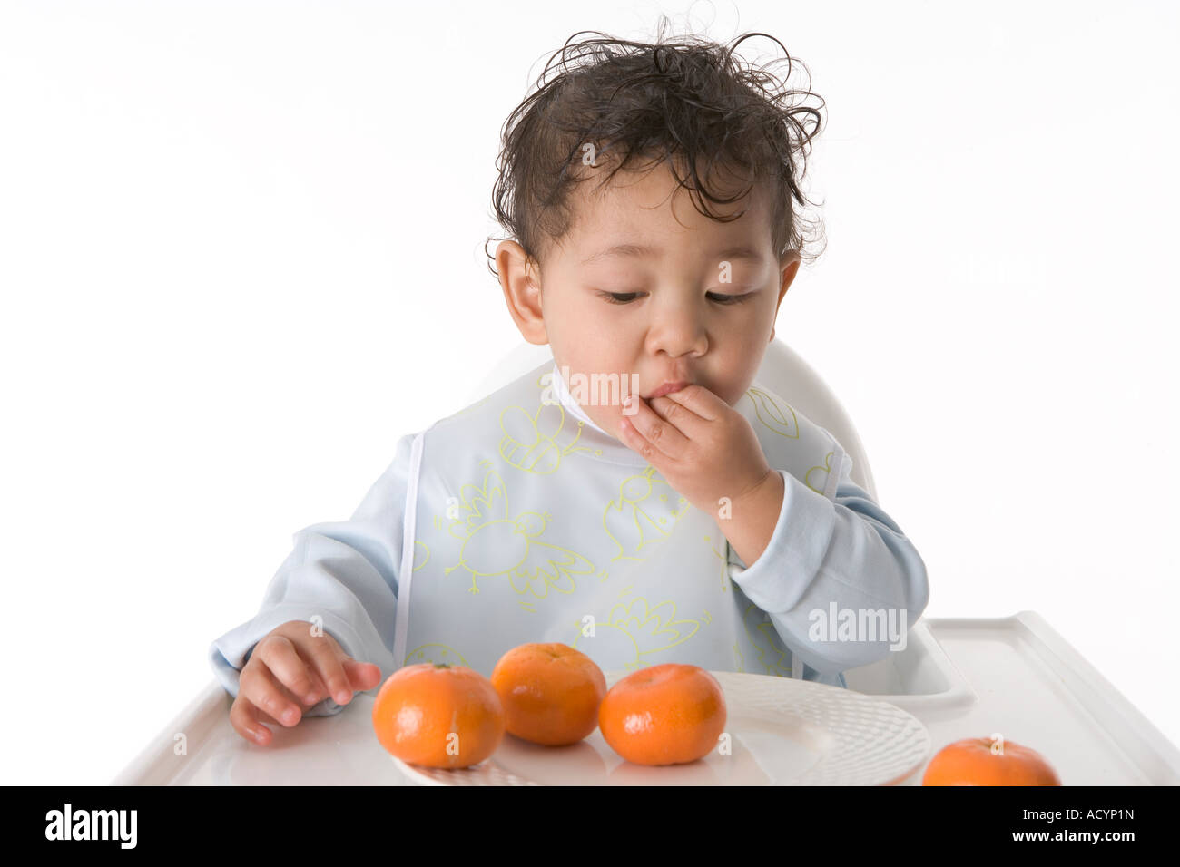 Little toddler boy eating a mandarin Stock Photo - Alamy