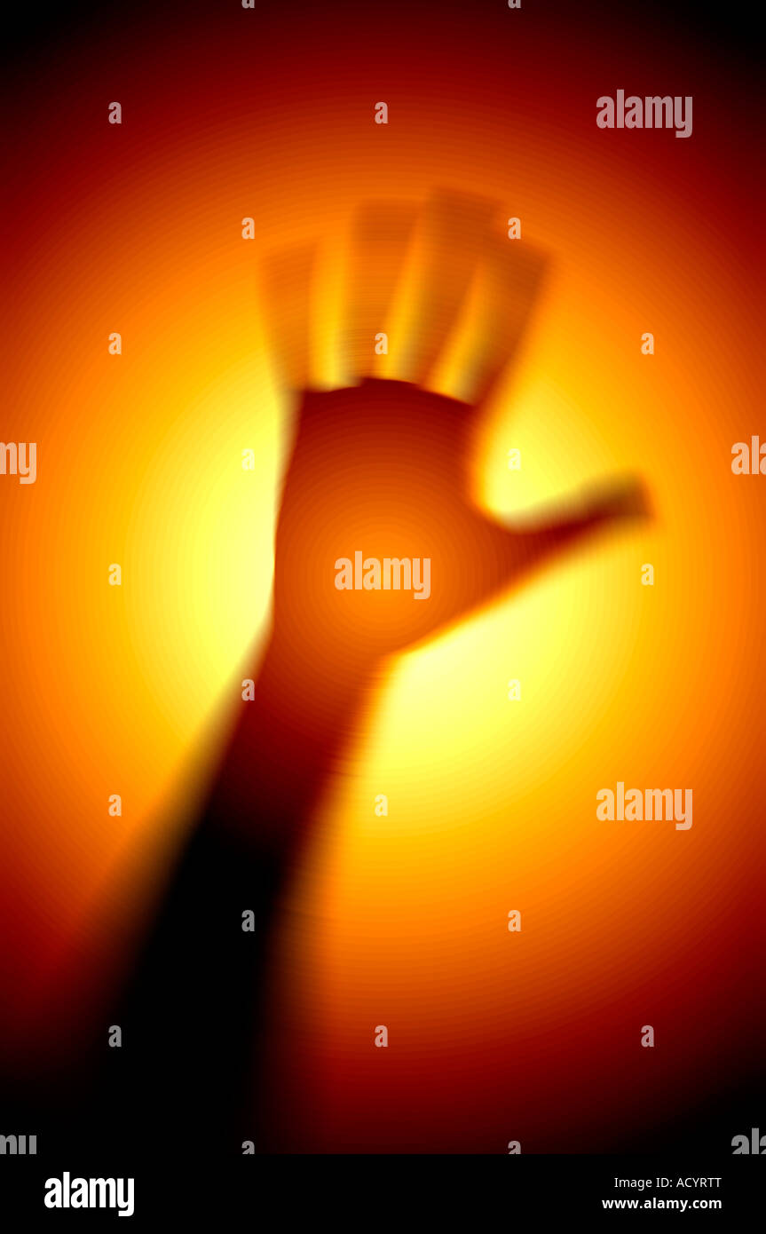 conceptual view of a grasping blurred hand behind glowing frosted glass ...