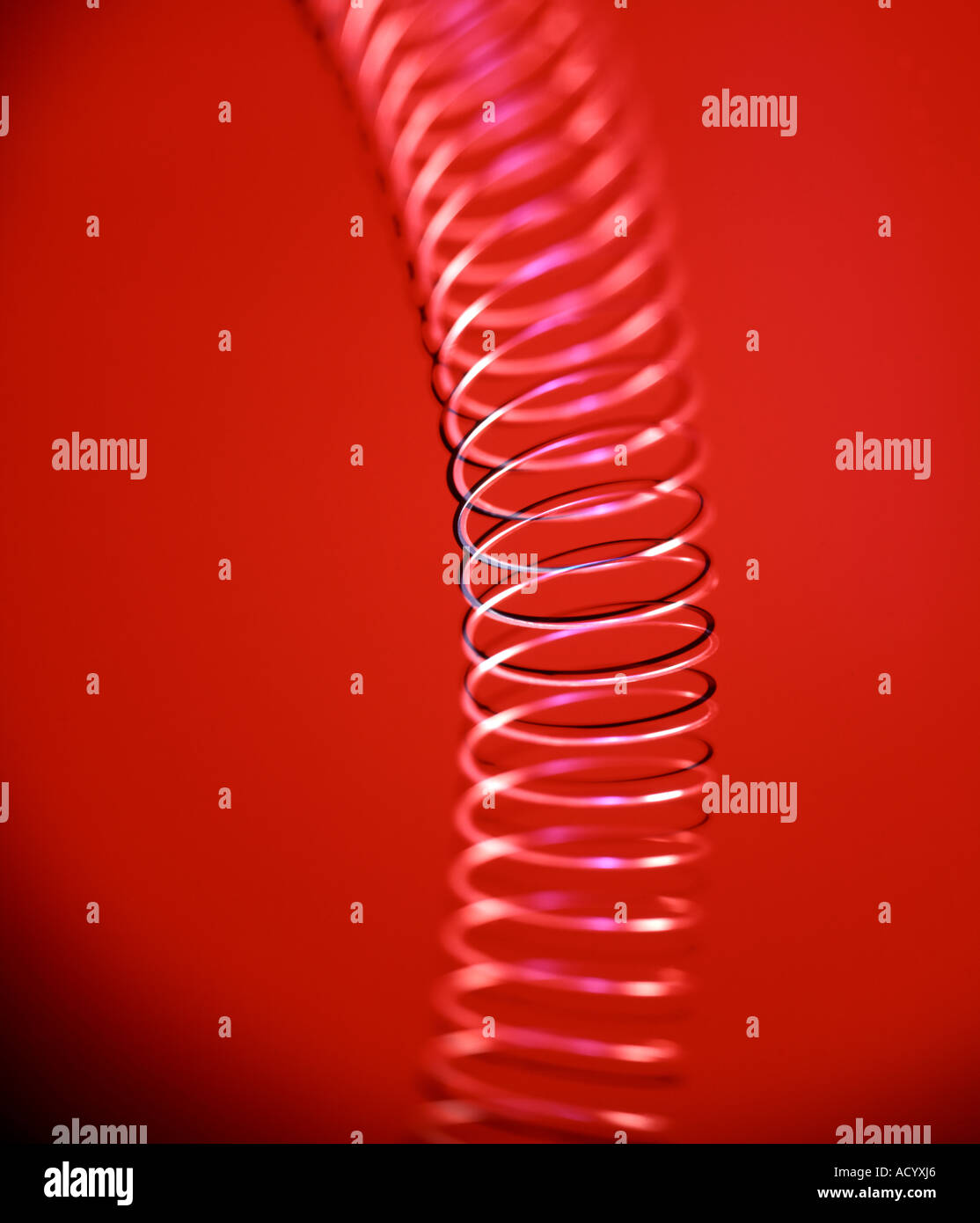 Spring unravelled with a red background Stock Photo - Alamy