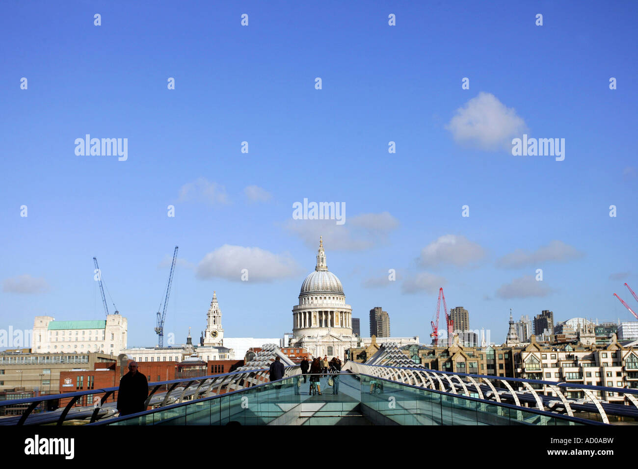 People walk over the Millenium Bridge towards St Pauls Cathedral London ...